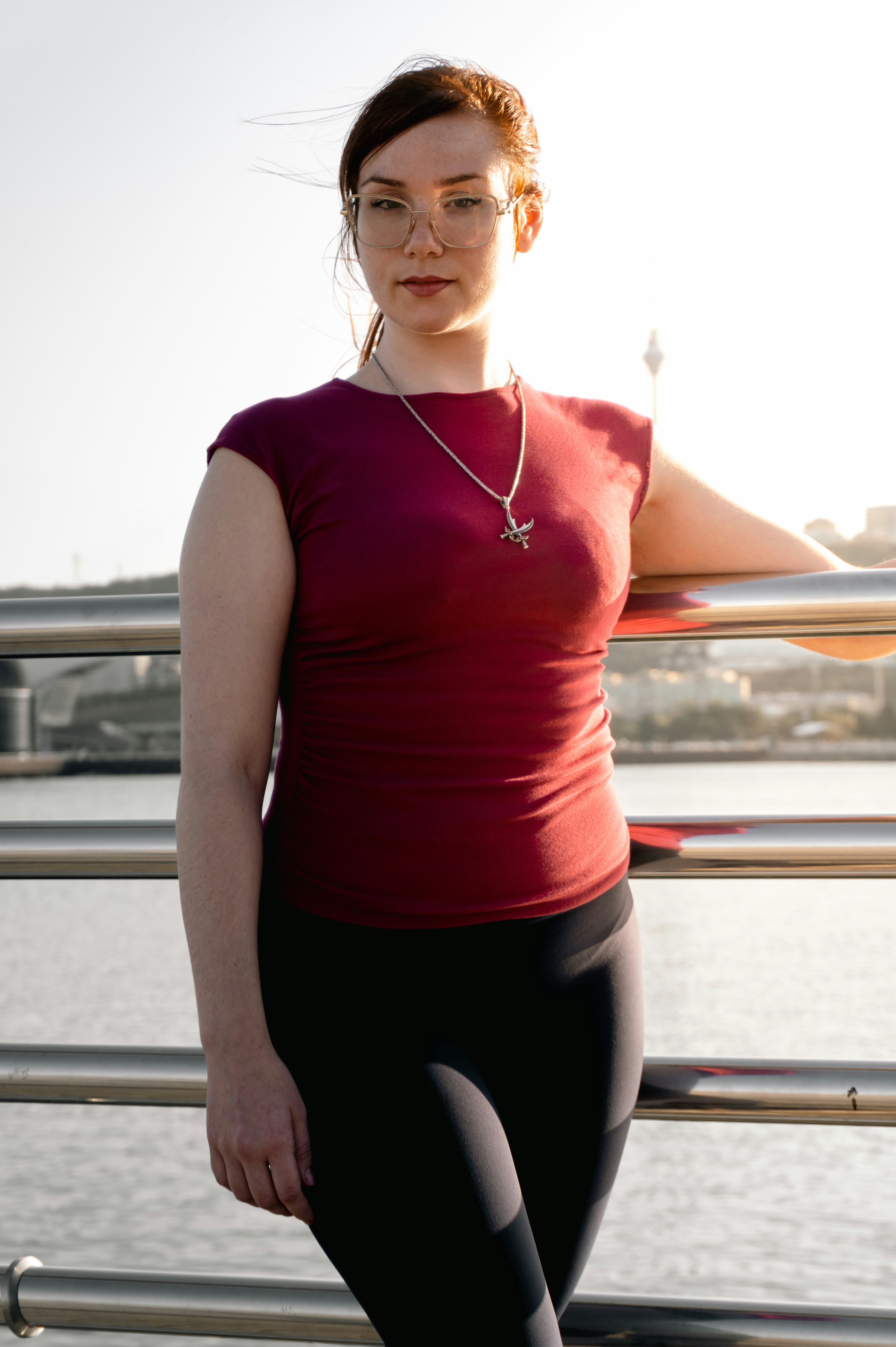 Riverside Confidence: Burgundy Top Portrait by the Rail