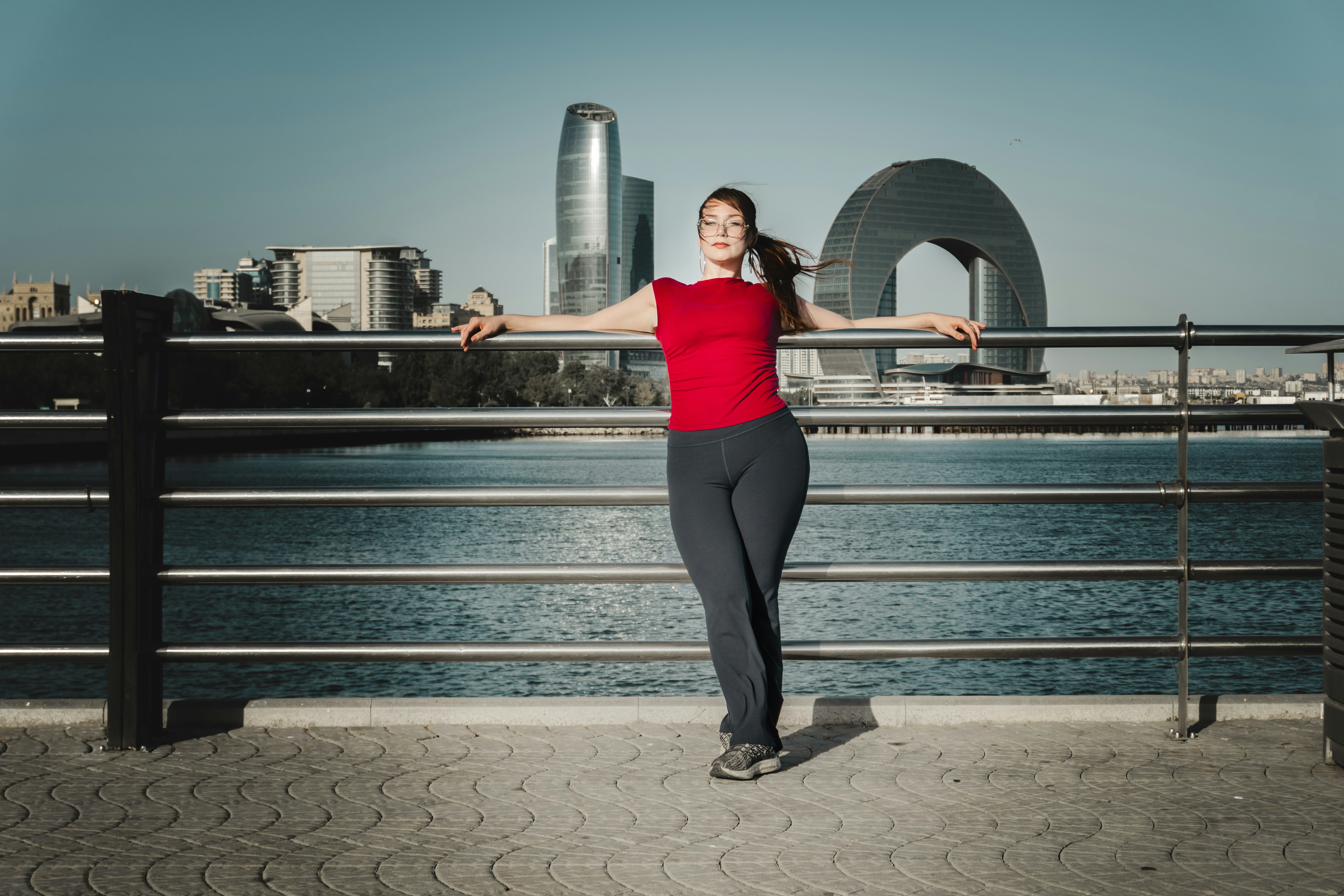 Crimson Poise by the Harbor: Portrait against a Modern City Arc
