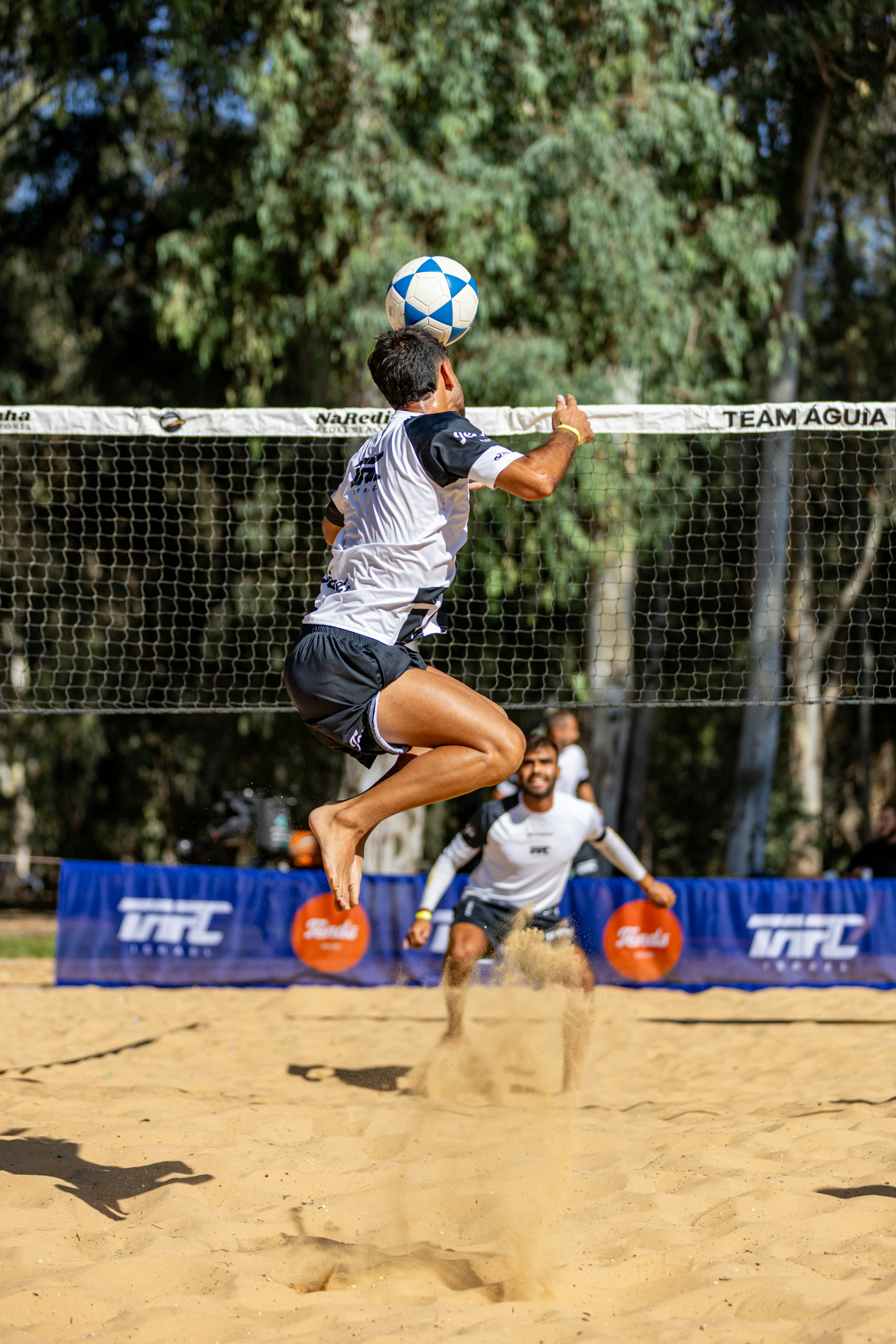 Man playing beach soccer in mid-air