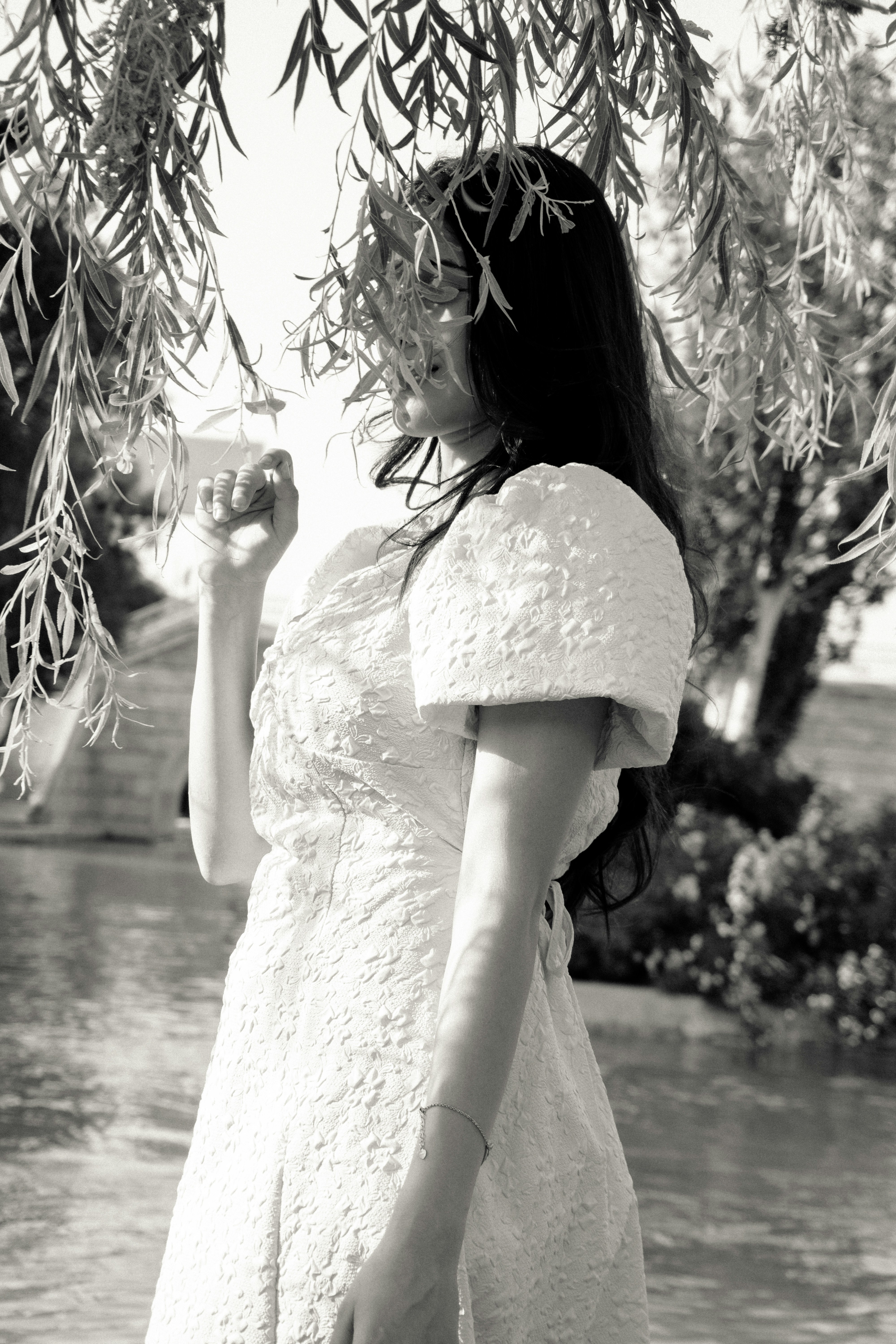 Woman in white dress under weeping willow tree