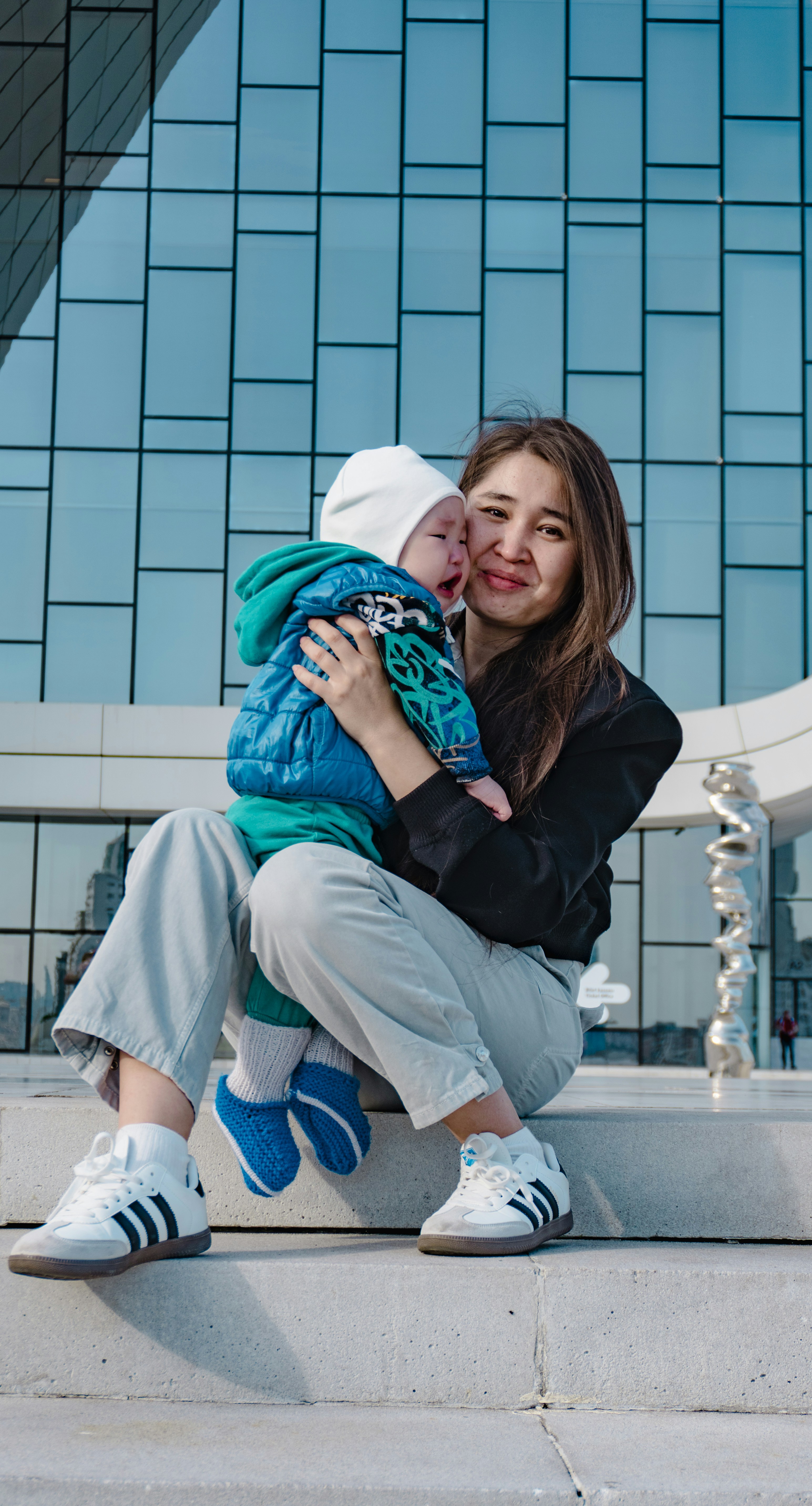 City Glass Hug: Mother and Child on a Blue Facade