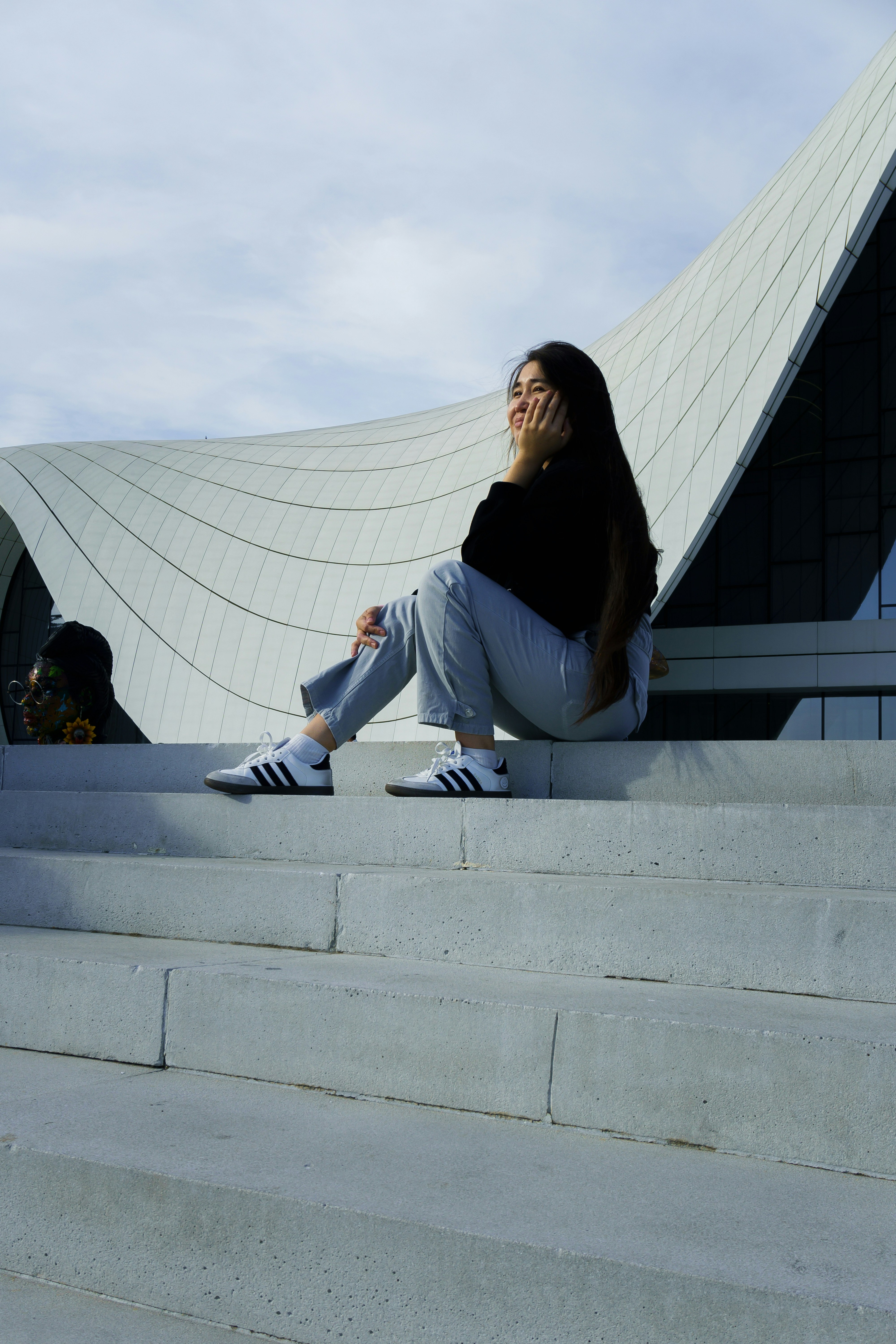 Concrete Steps and a Quiet Gaze Beneath the Curved Roof