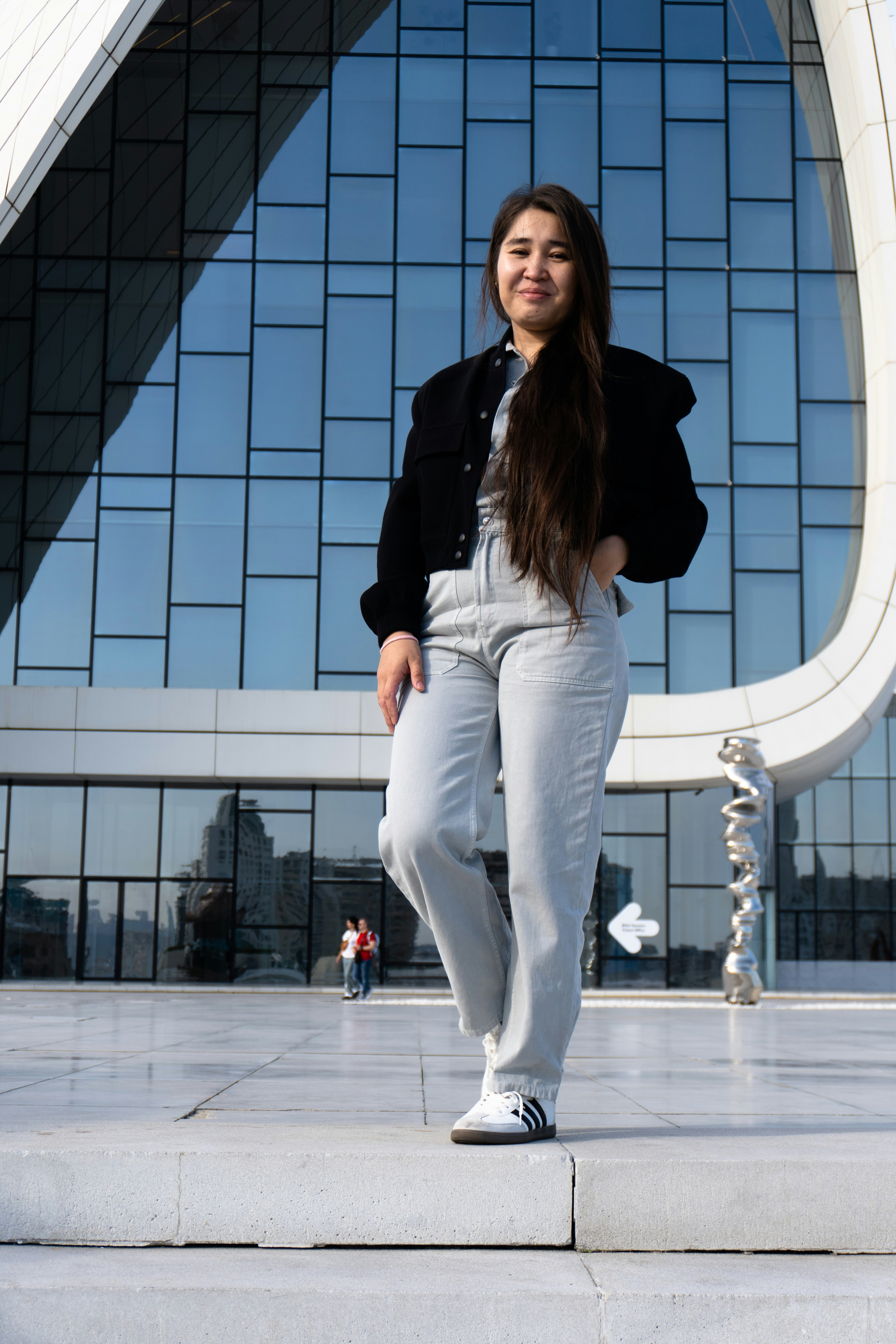Casual Confidence Before a Blue Glass Facade