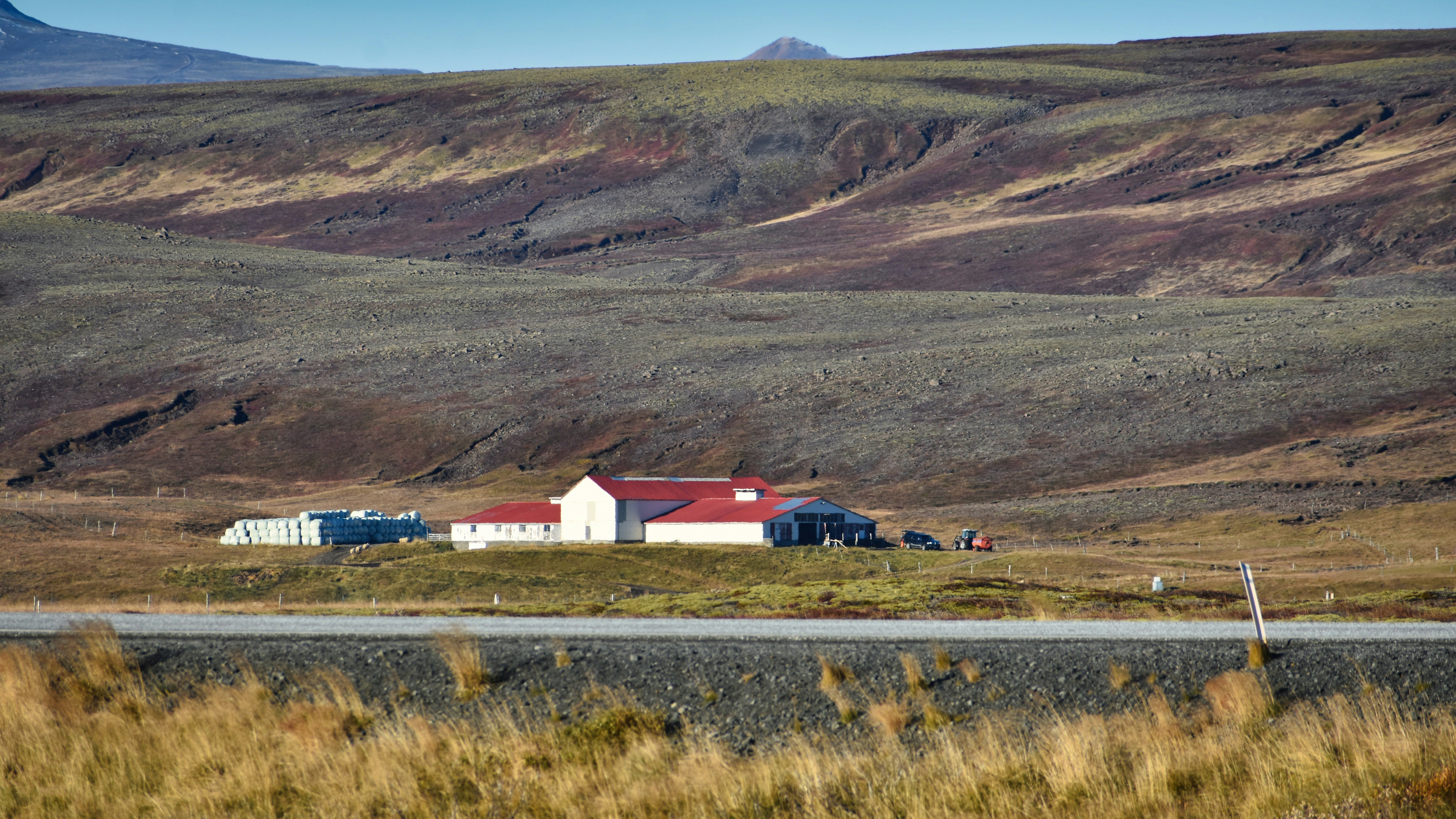 Red-Roofed Farmstead on a Desolate Volcanic Plain