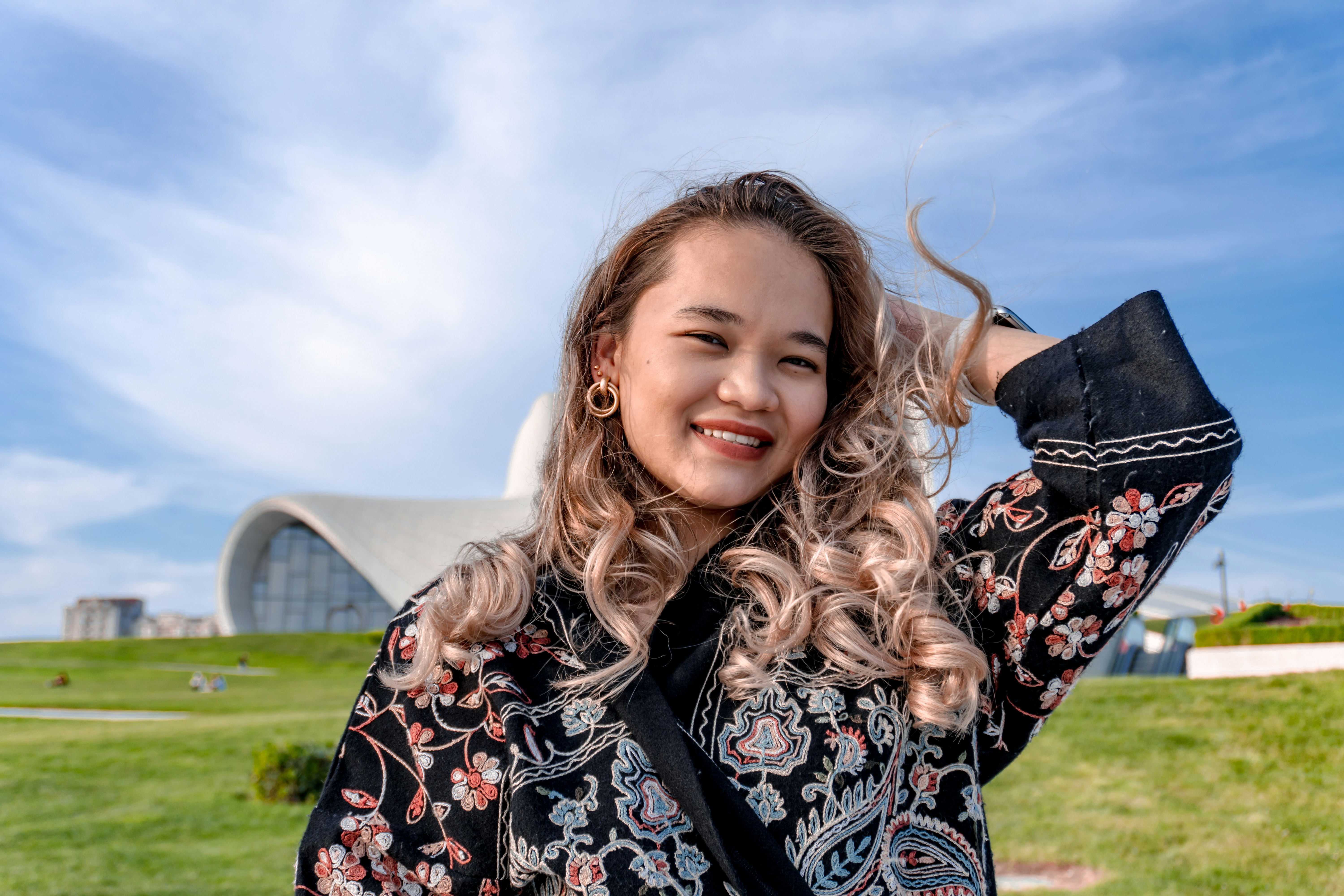 Wind-Swept Confidence in a Floral Jacket at a Sunlit Park