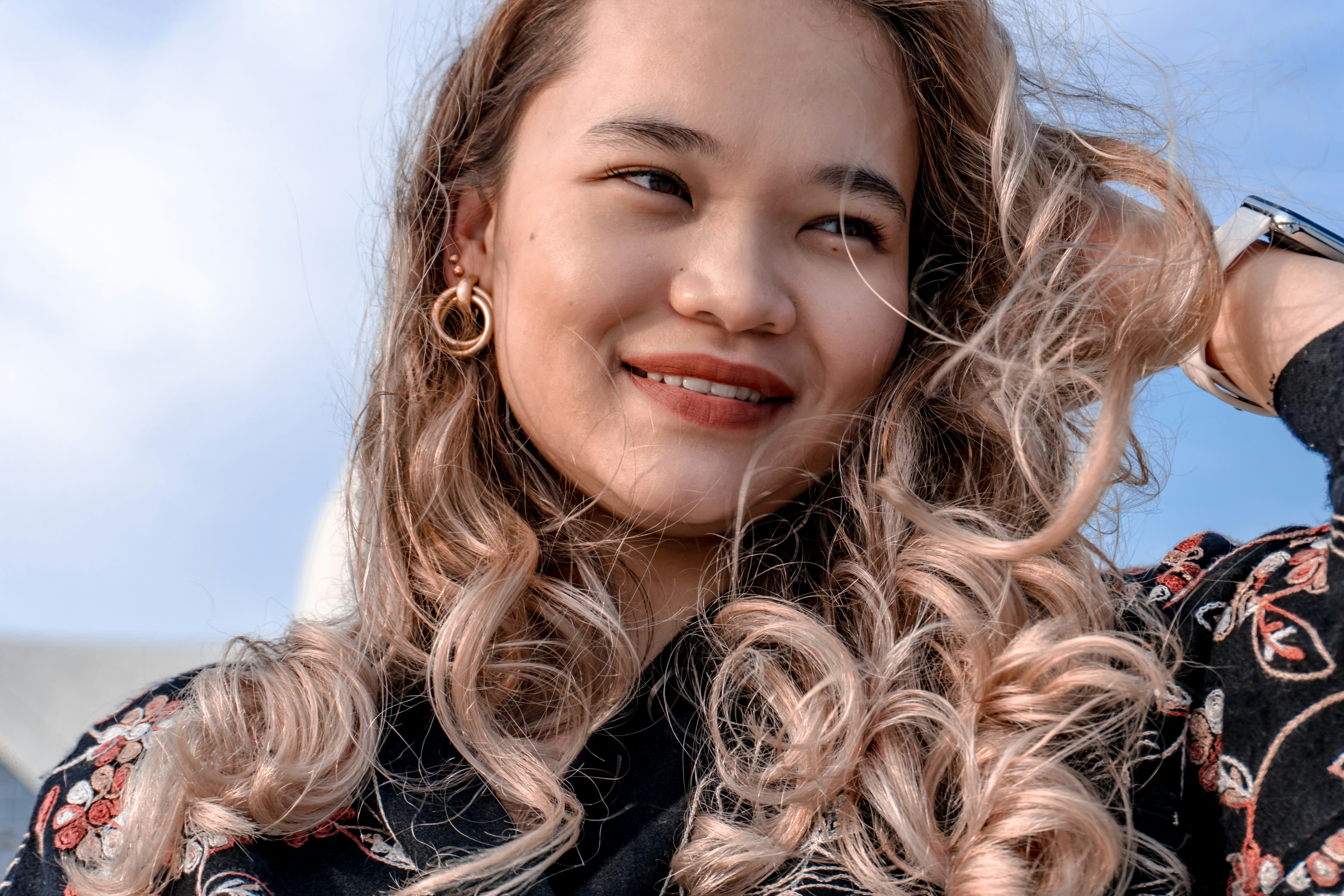 Wind-Kissed Portrait: Amber Curls and a Warm Smile