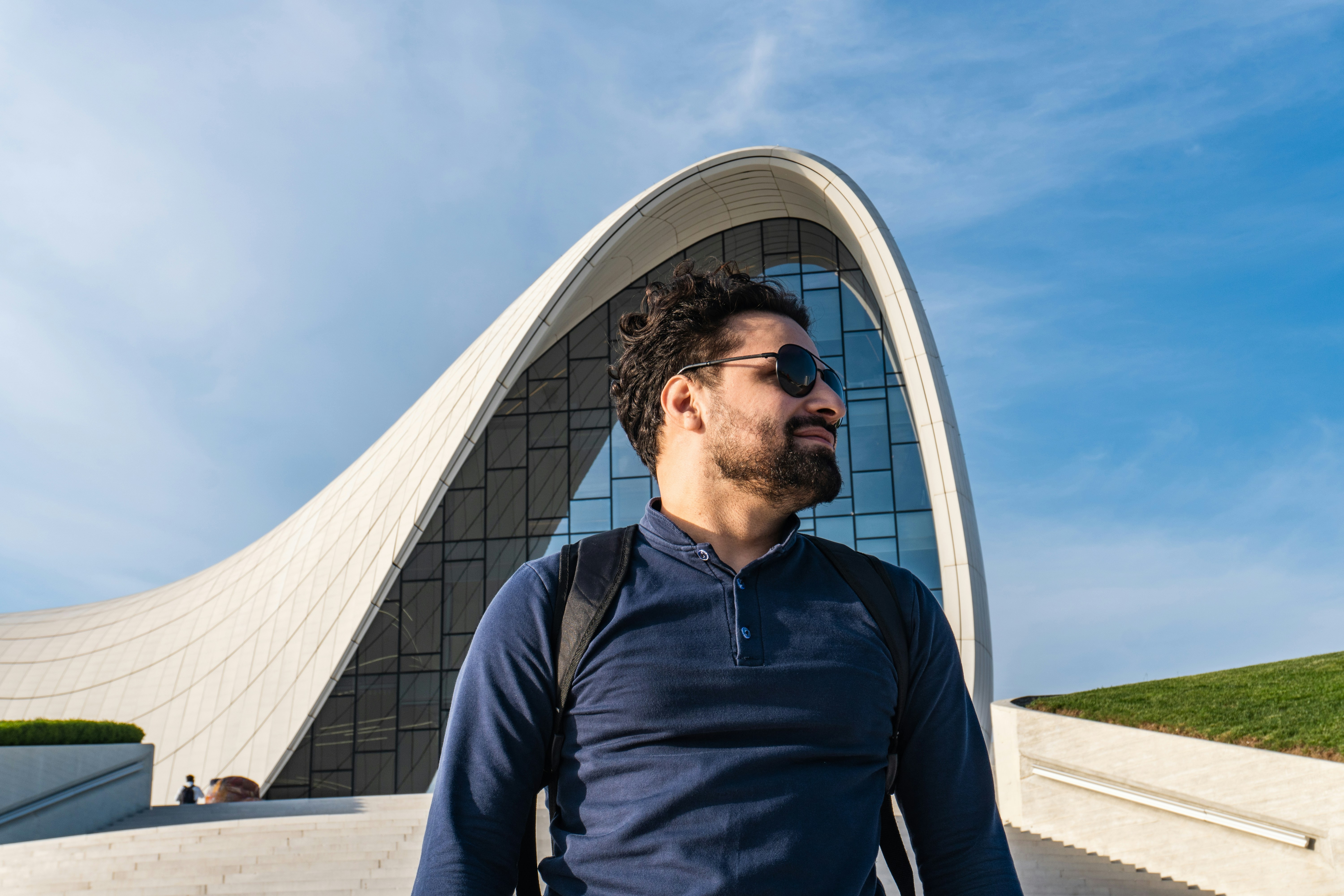 Portrait Beneath a Sweeping Arch: A Quiet Presence Against Modern Curves