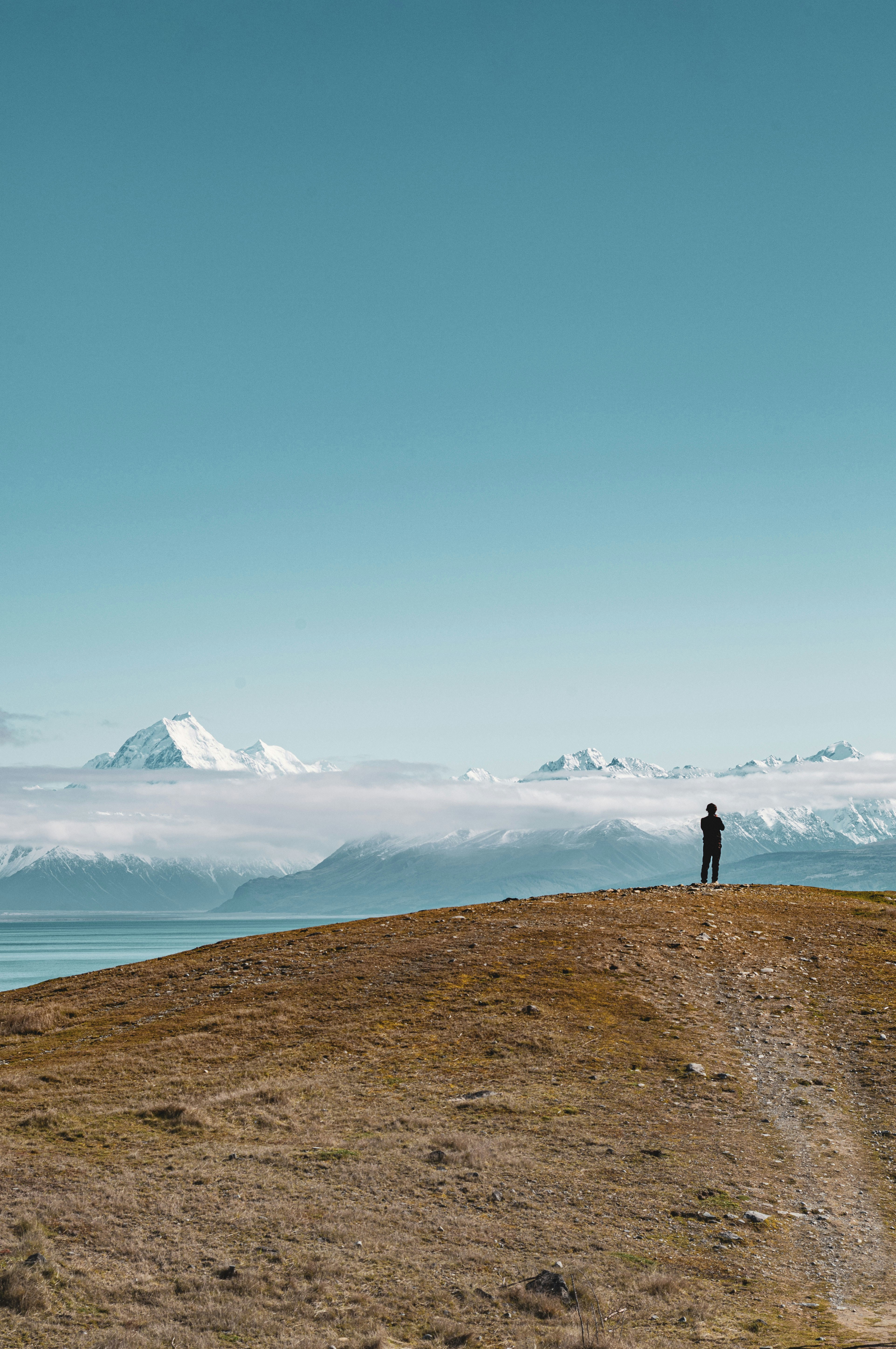 Ridgewalker Against a Sea of Clouds and Snow-Capped Peaks