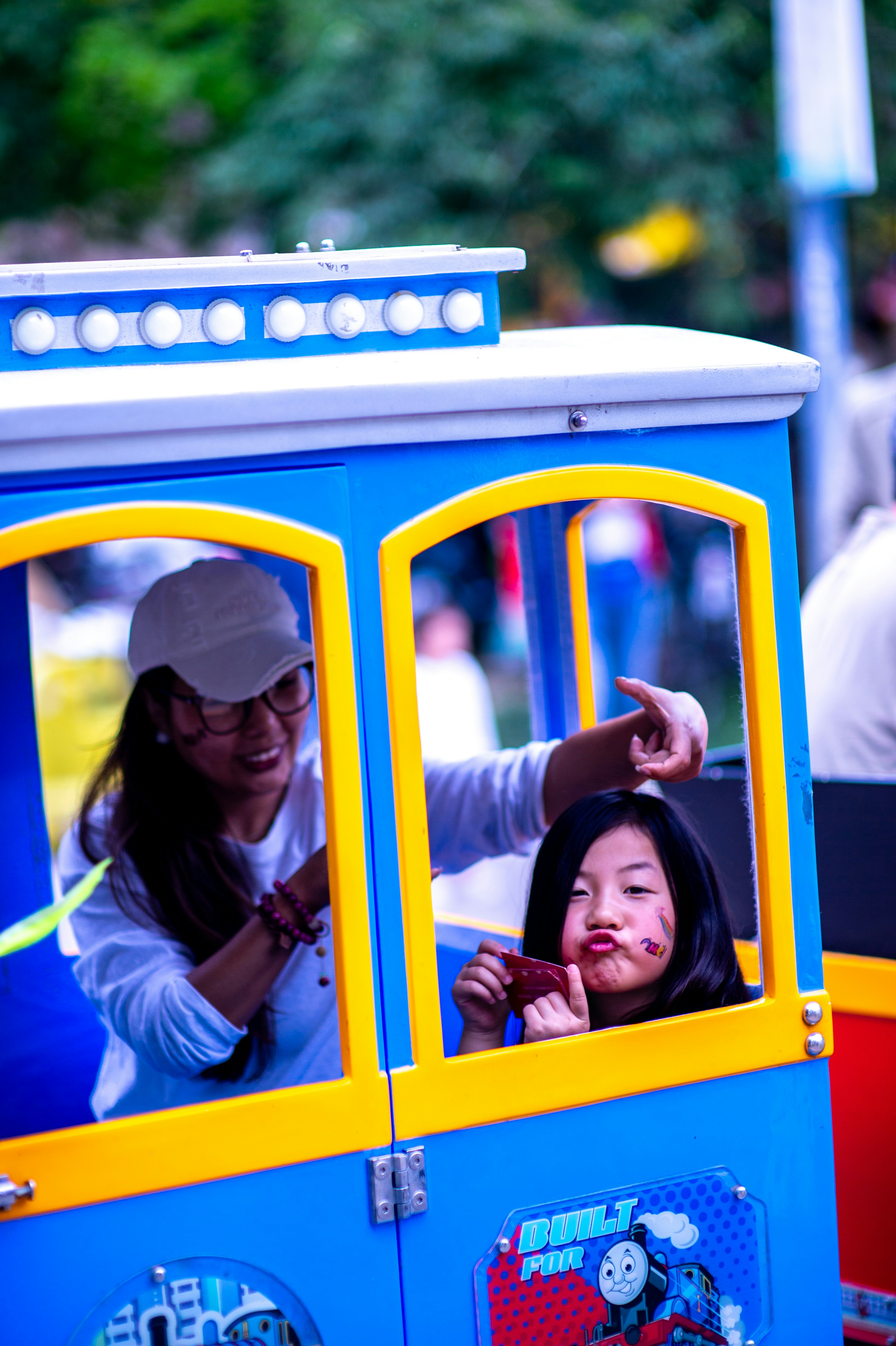Color-Block Kiddie Cab: A candid moment through the ride's yellow-framed window