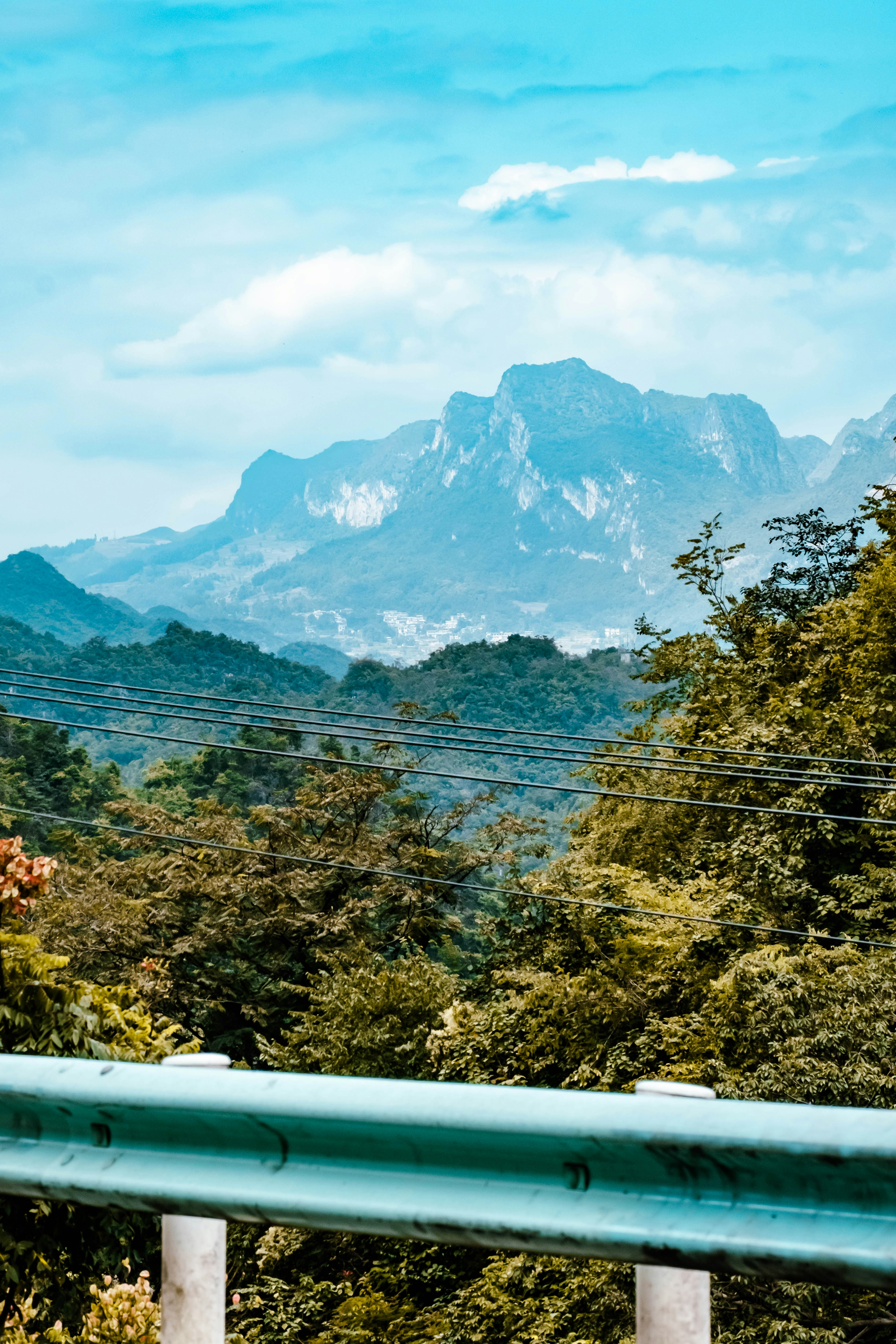 Azure Summit Behind the Wires: Mountain Ridge Beyond the Guardrail