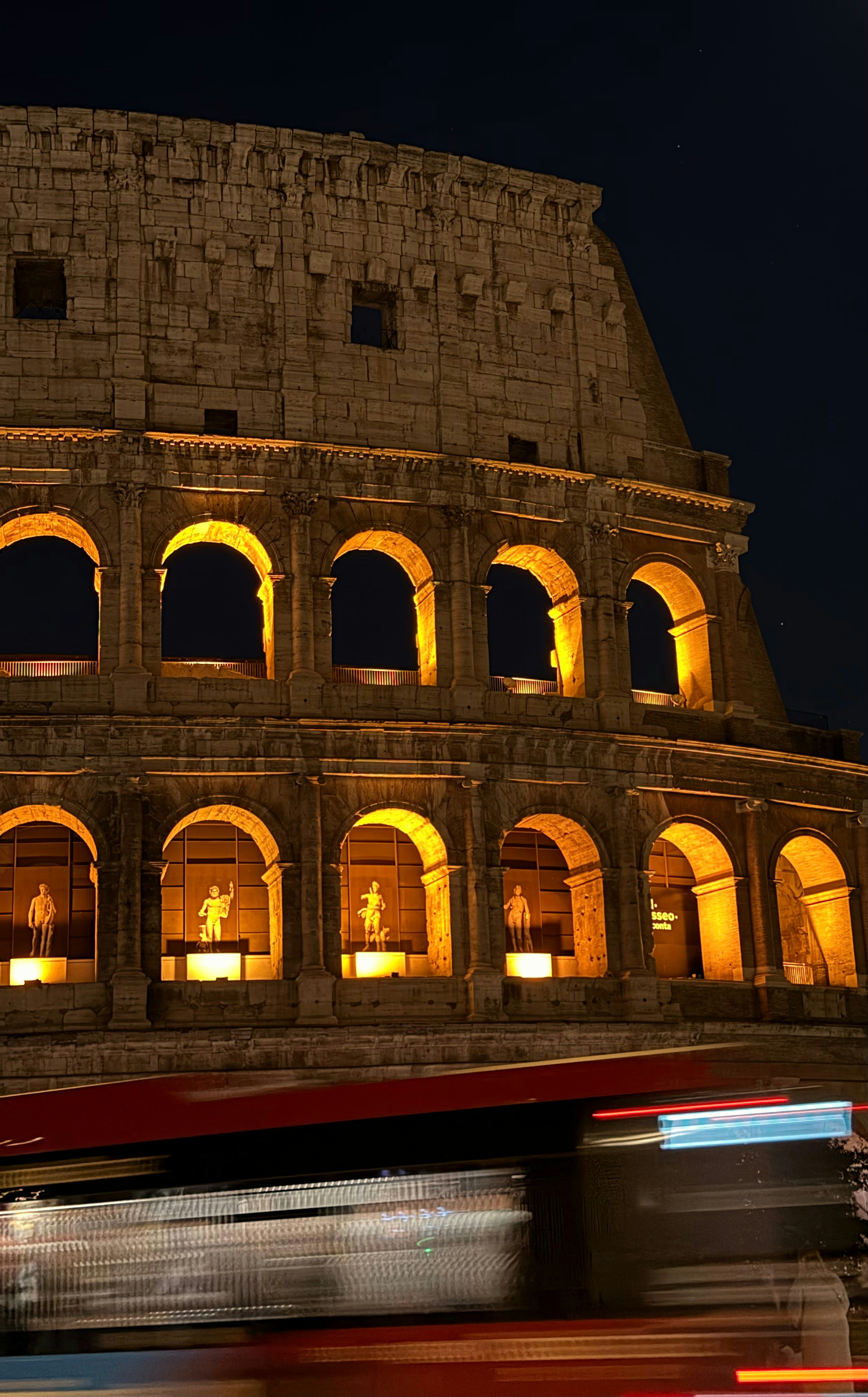 Amber Arches at Night: Colosseum Facade Illuminated Behind Streaking Lights