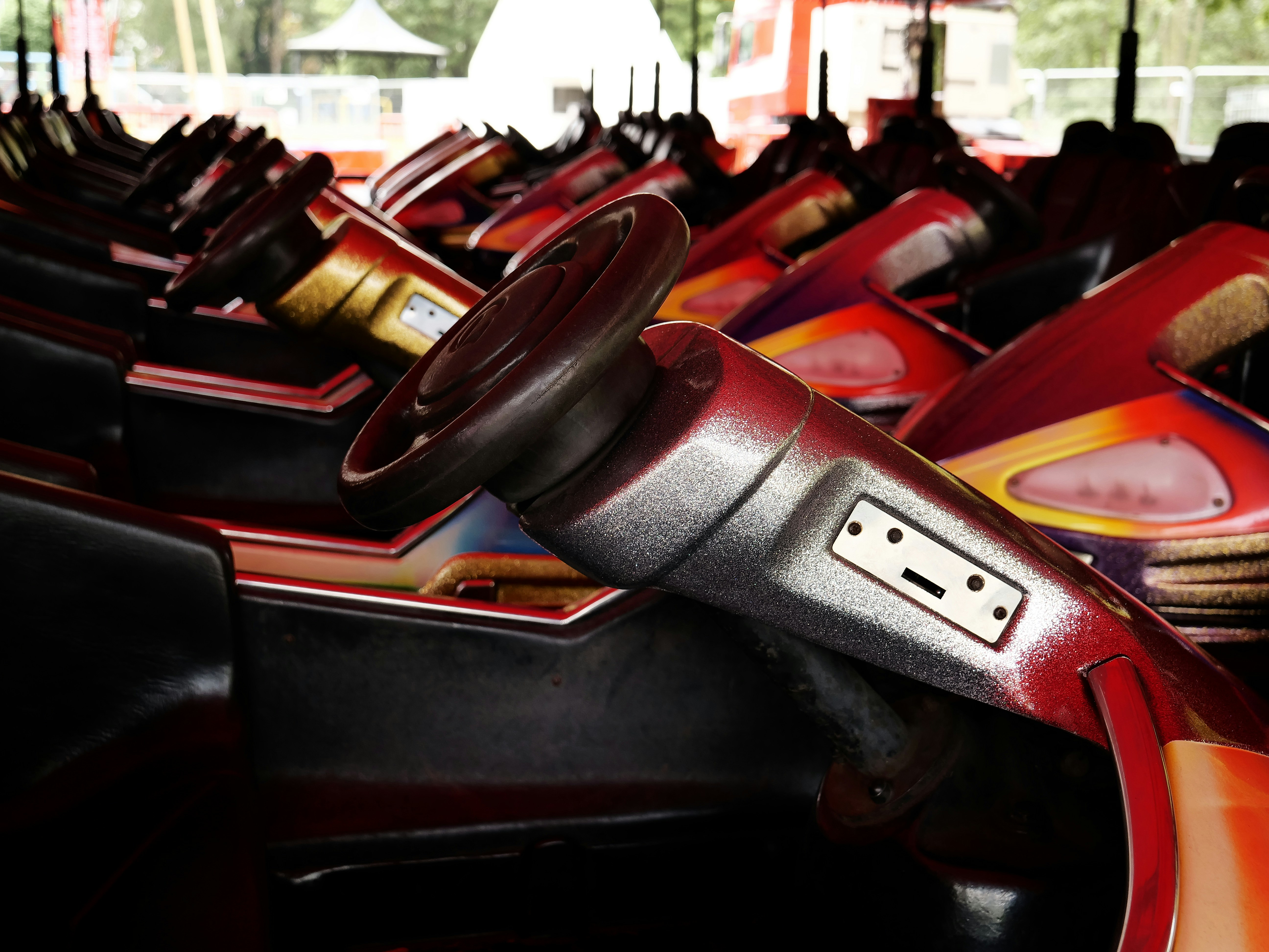 Chrome Grip, Red Rows: A Close-Up Portrait of Bumper Cars at the Fair