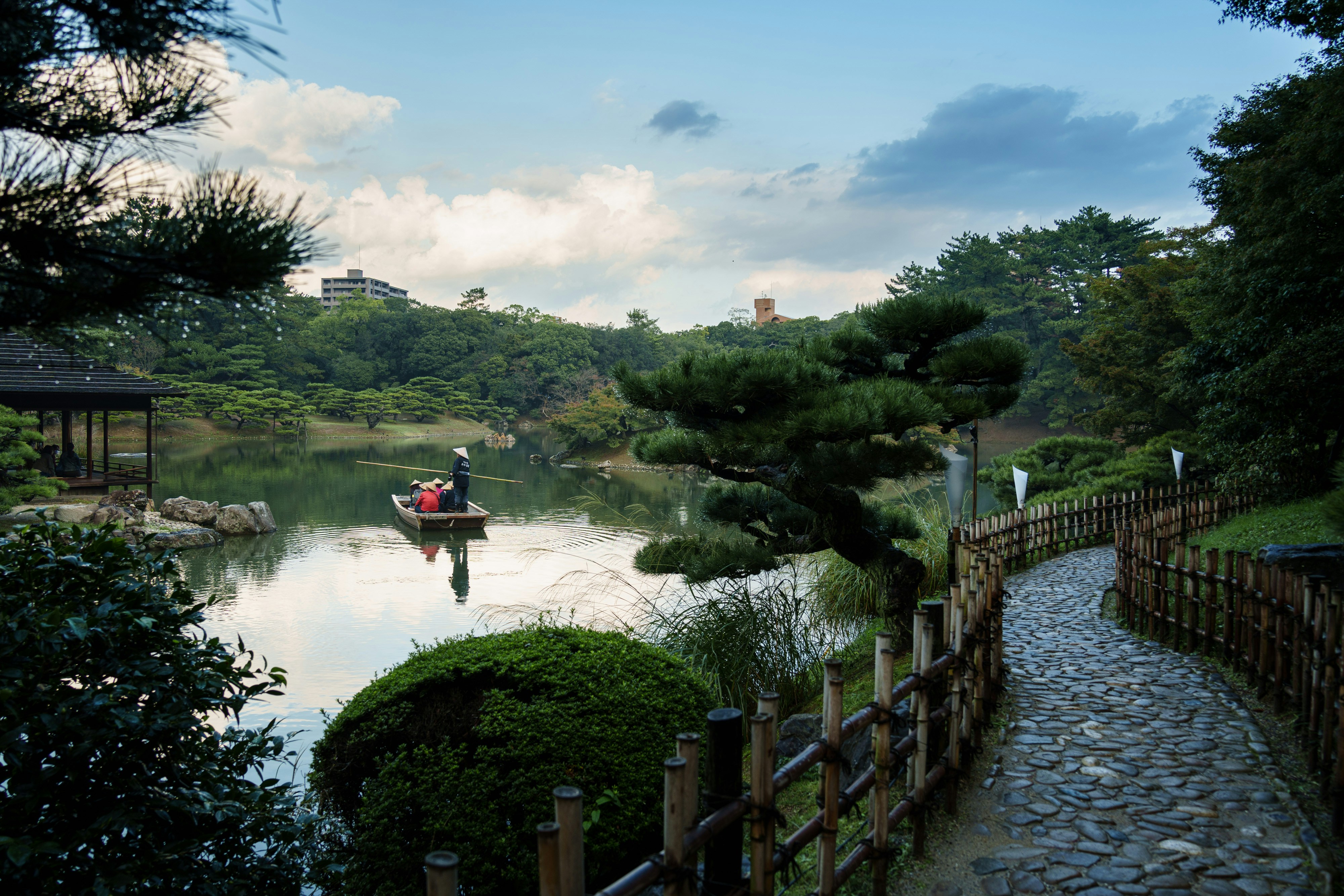 Lone Boat on a Serene Garden Pond Framed by a Pebble Path