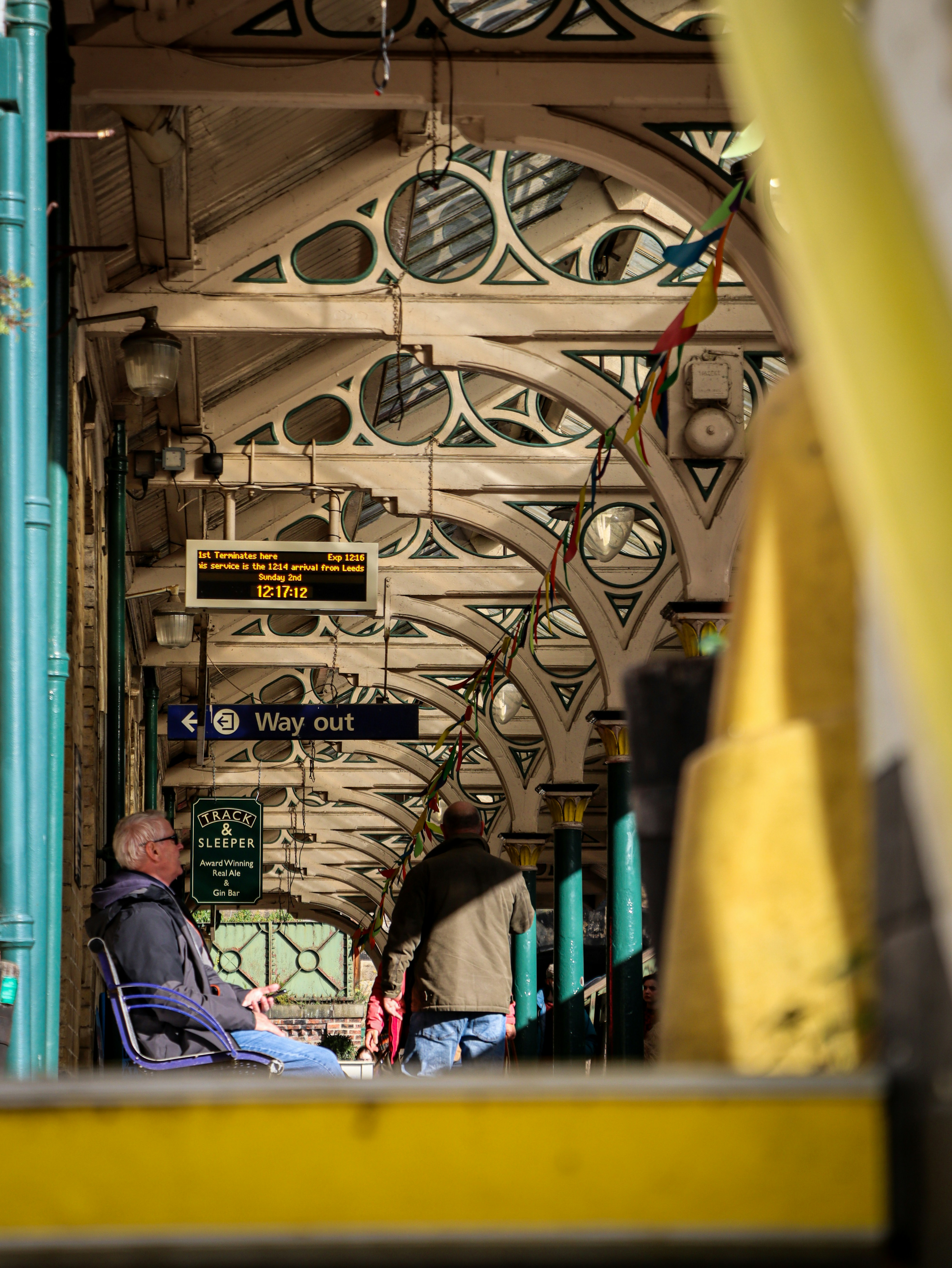 Archways in Motion: A Teal-Pillar Station Corridor Where Passersby Pause