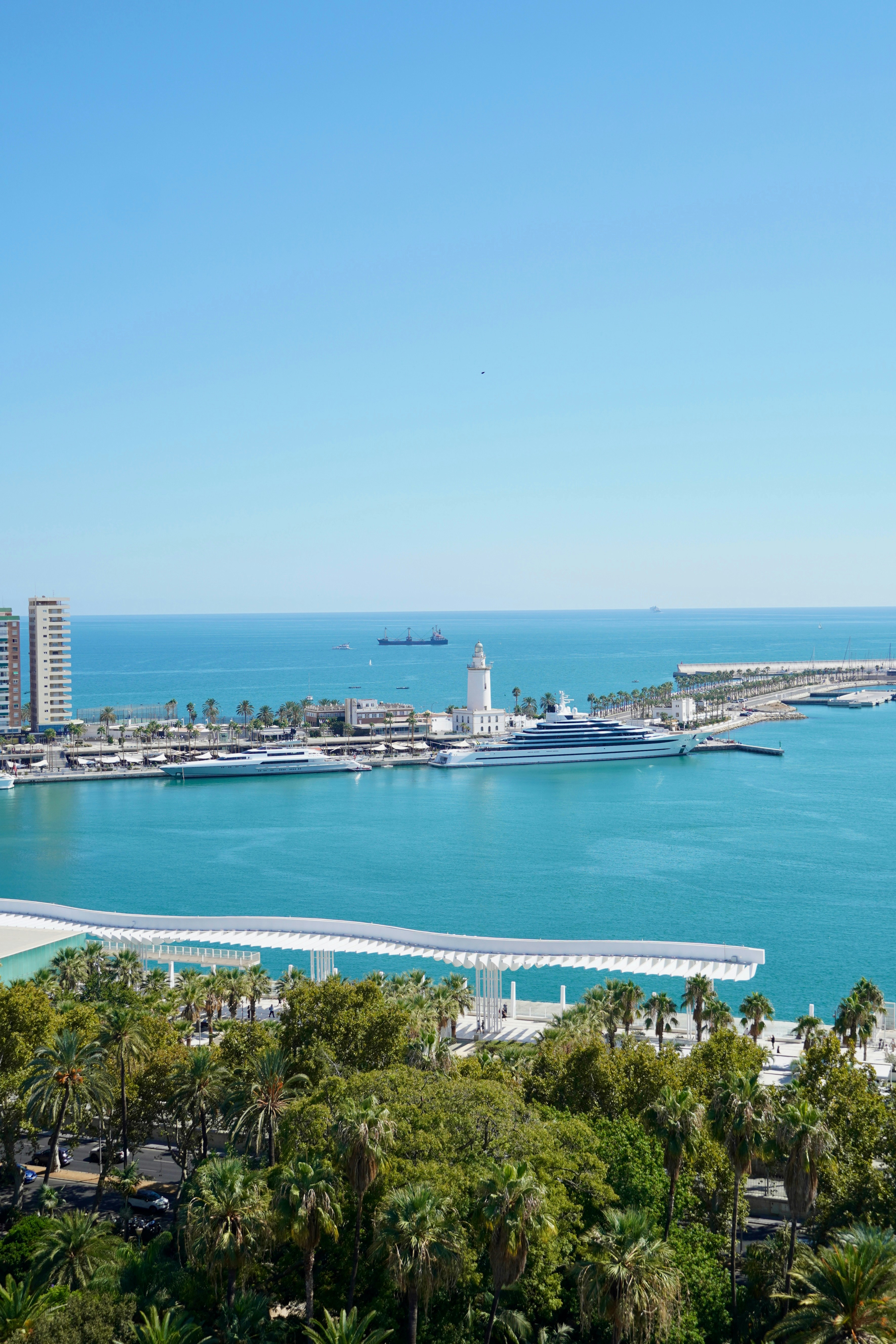 Azure Harbor: Yachts, Lighthouse, and a Palm-Striped Promenade