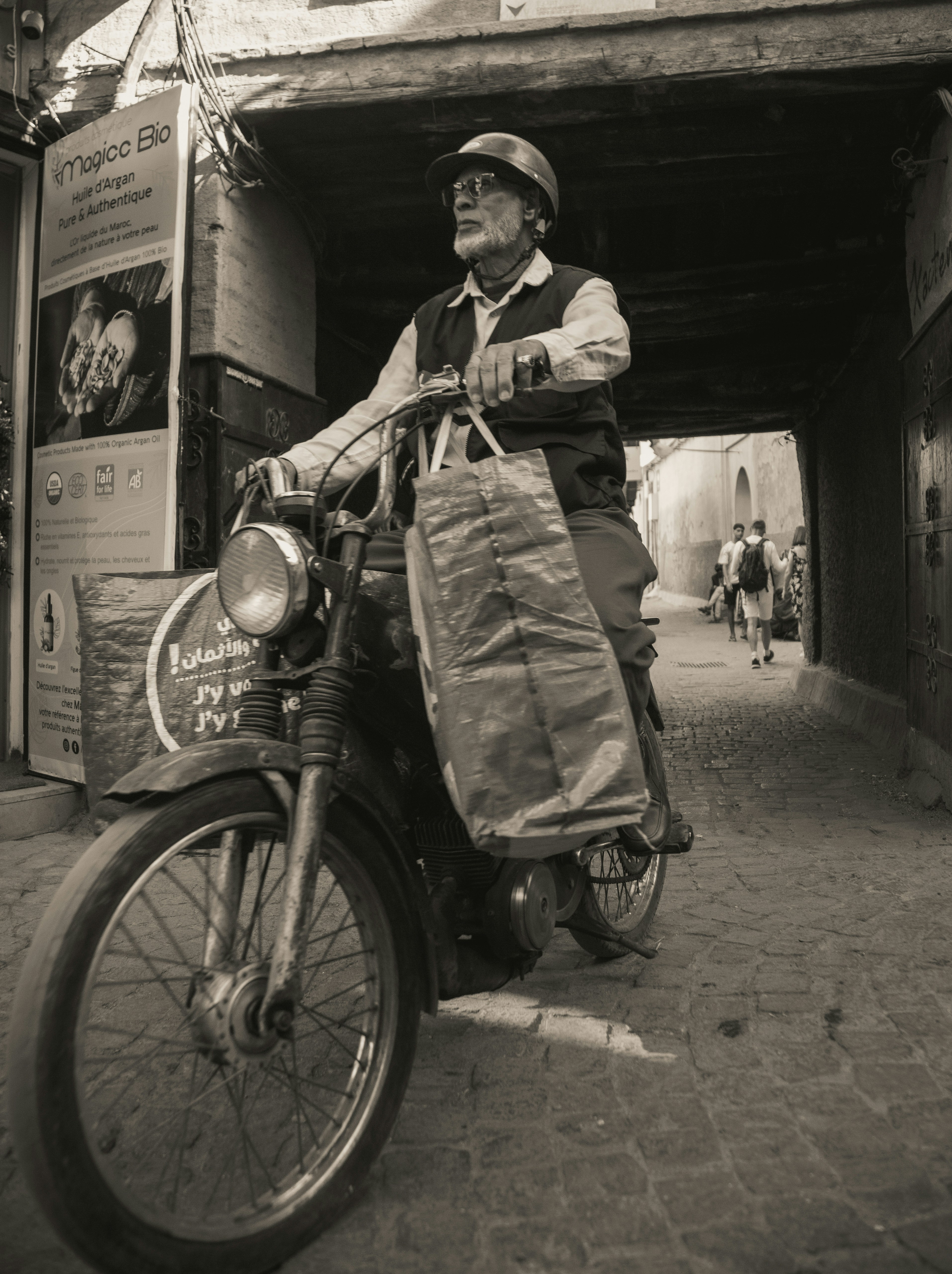 Under the Archway: A Weathered Rider Navigates a Narrow City Street