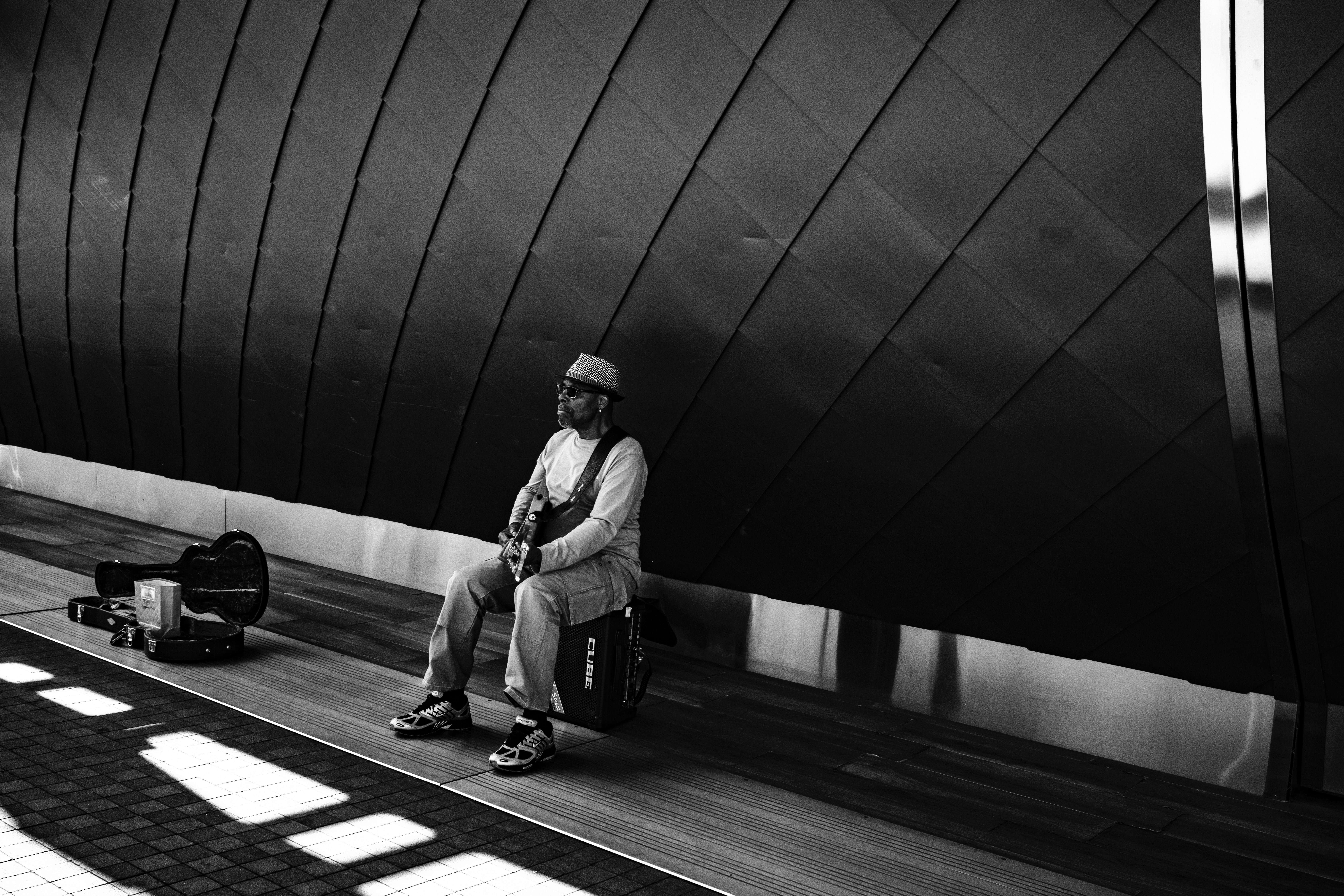 Metro Quietude: A lone guitarist on the curved platform edge