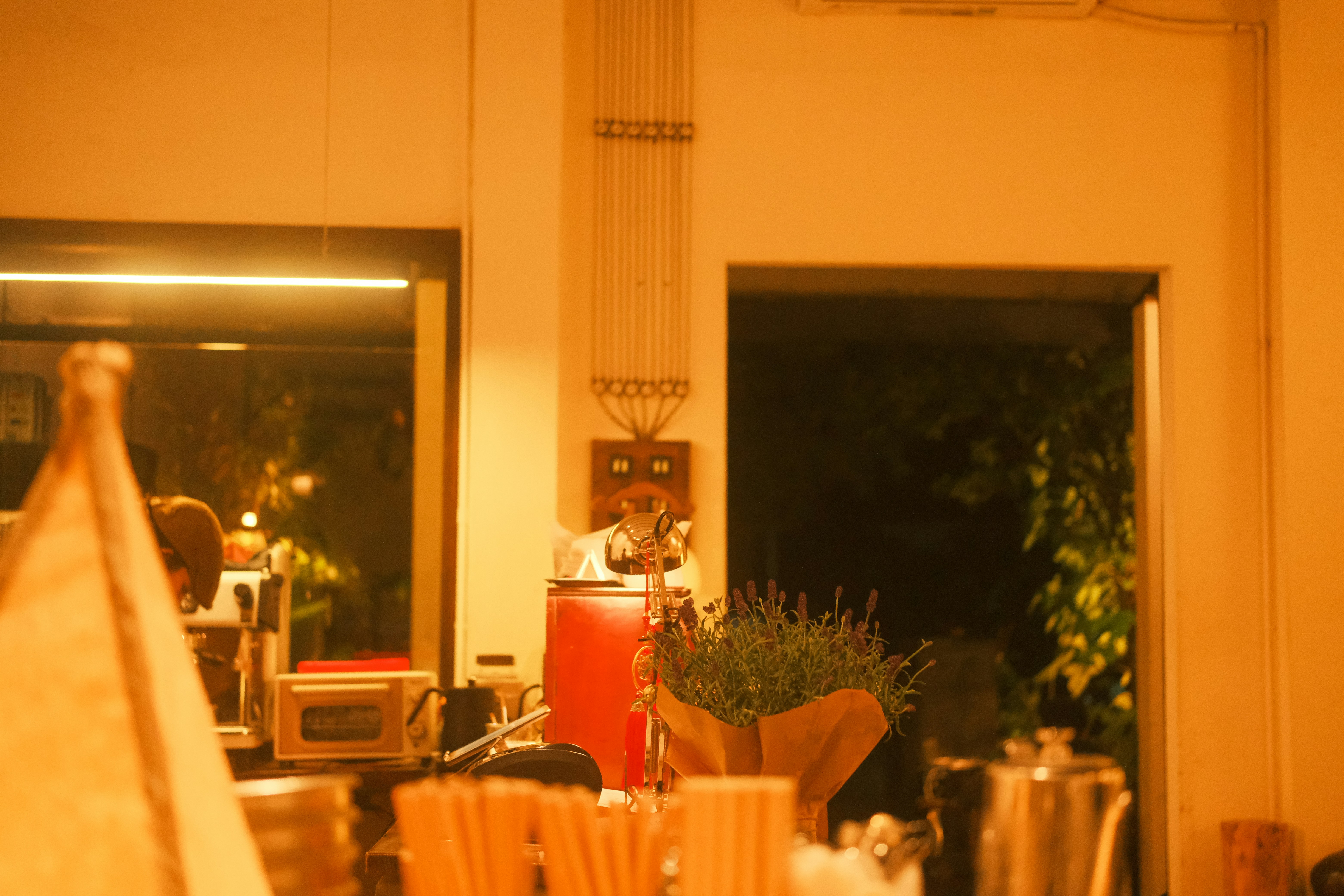Amber Glow and a Quiet Plant: A Café Table in Ambient Light
