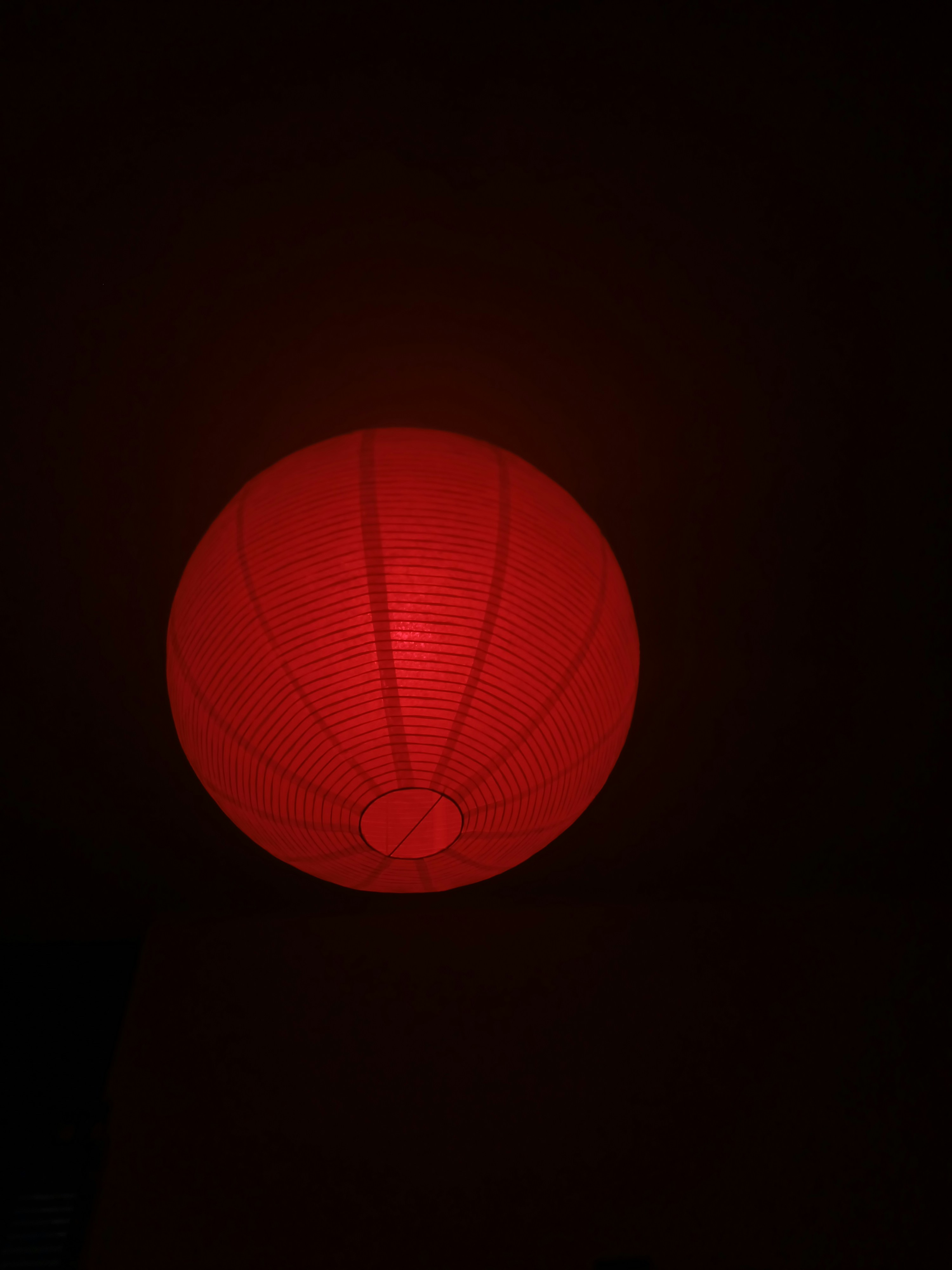 A red paper lantern glows in the dark.