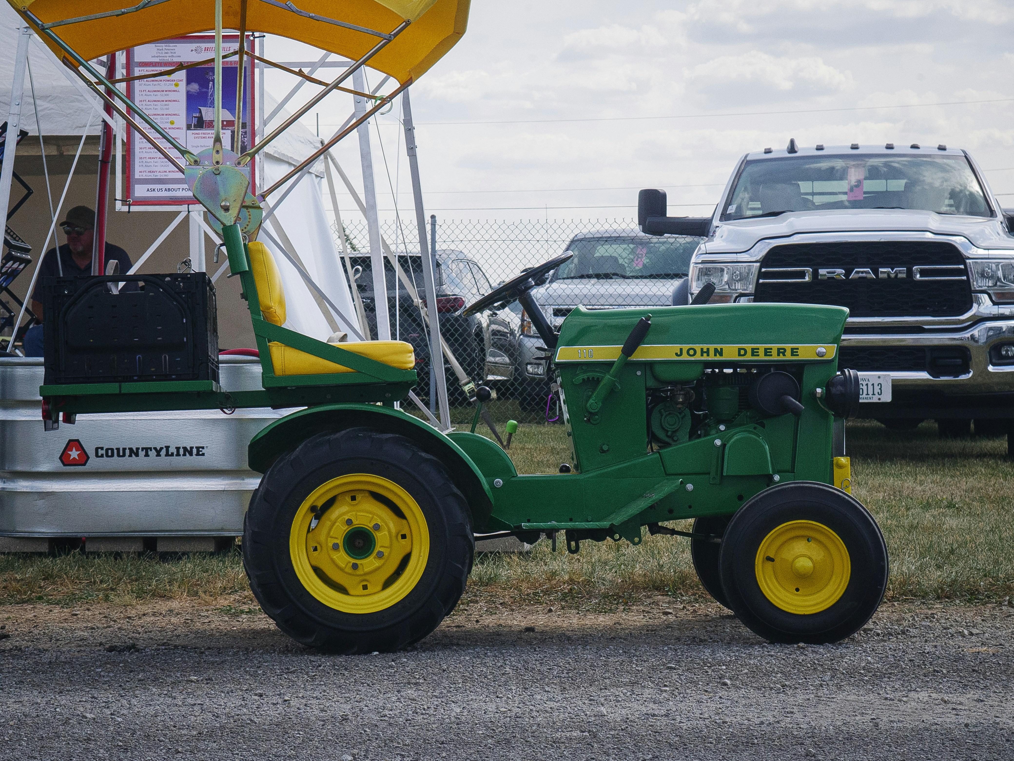 Green Powerhouse on Gravel: A Vintage John Deere Anchors the Fairground Scene