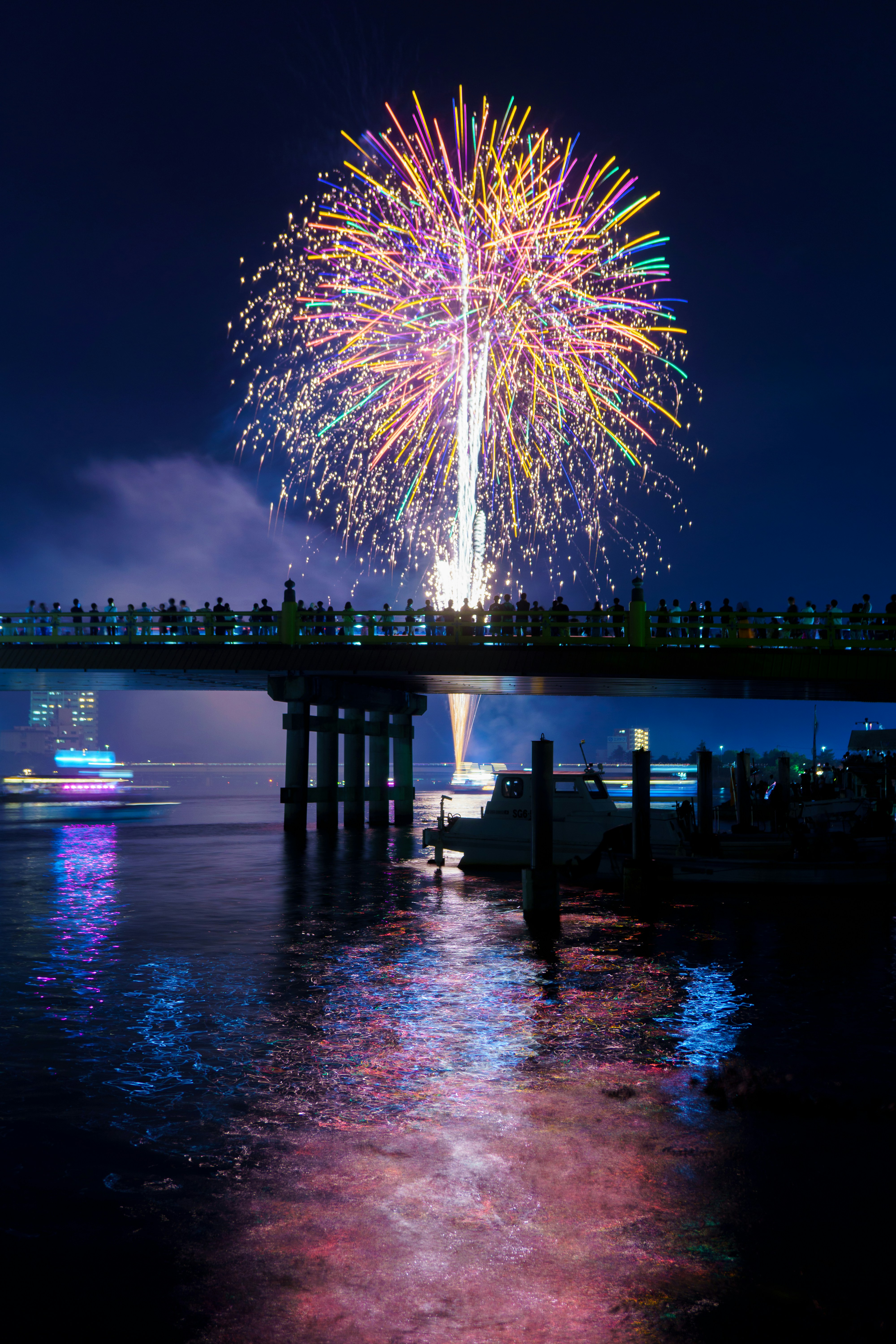 Midnight Burst Over the Bridge: Neon Fireworks Reflections on the River