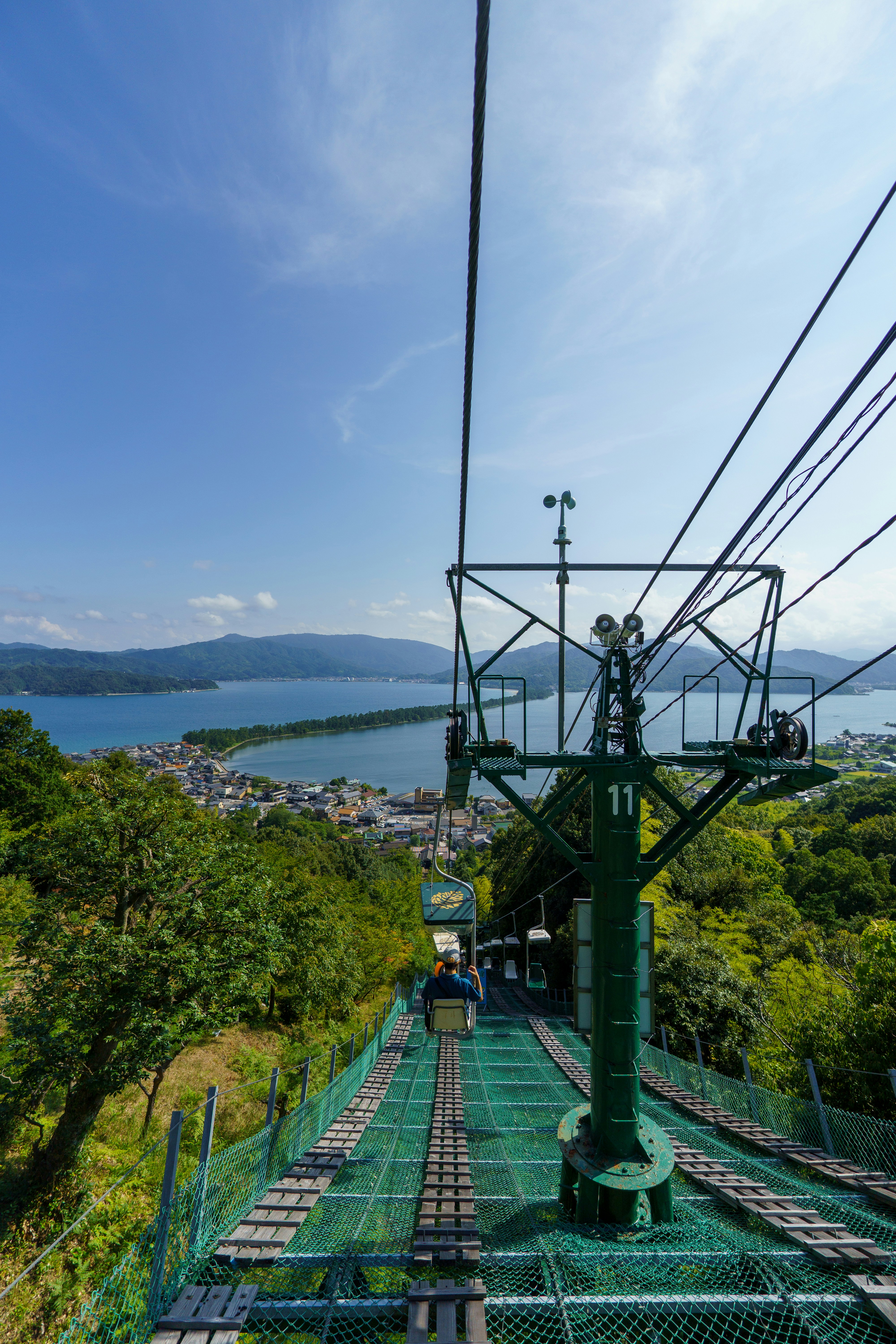 Emerald Spine: Cable Car Climb Over a Sunlit Seaside Town