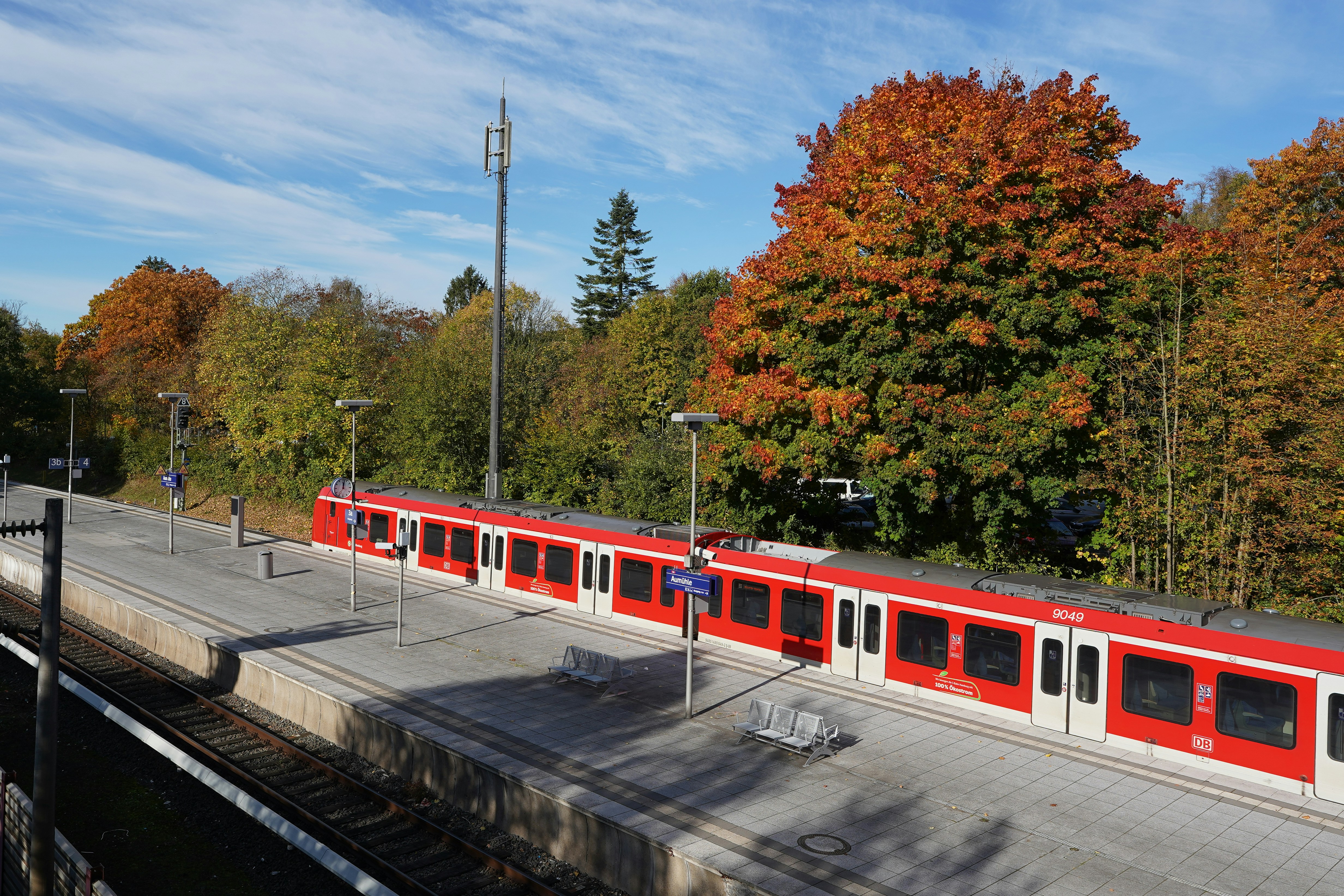 Crimson Commuter on a Sunlit Autumn Platform