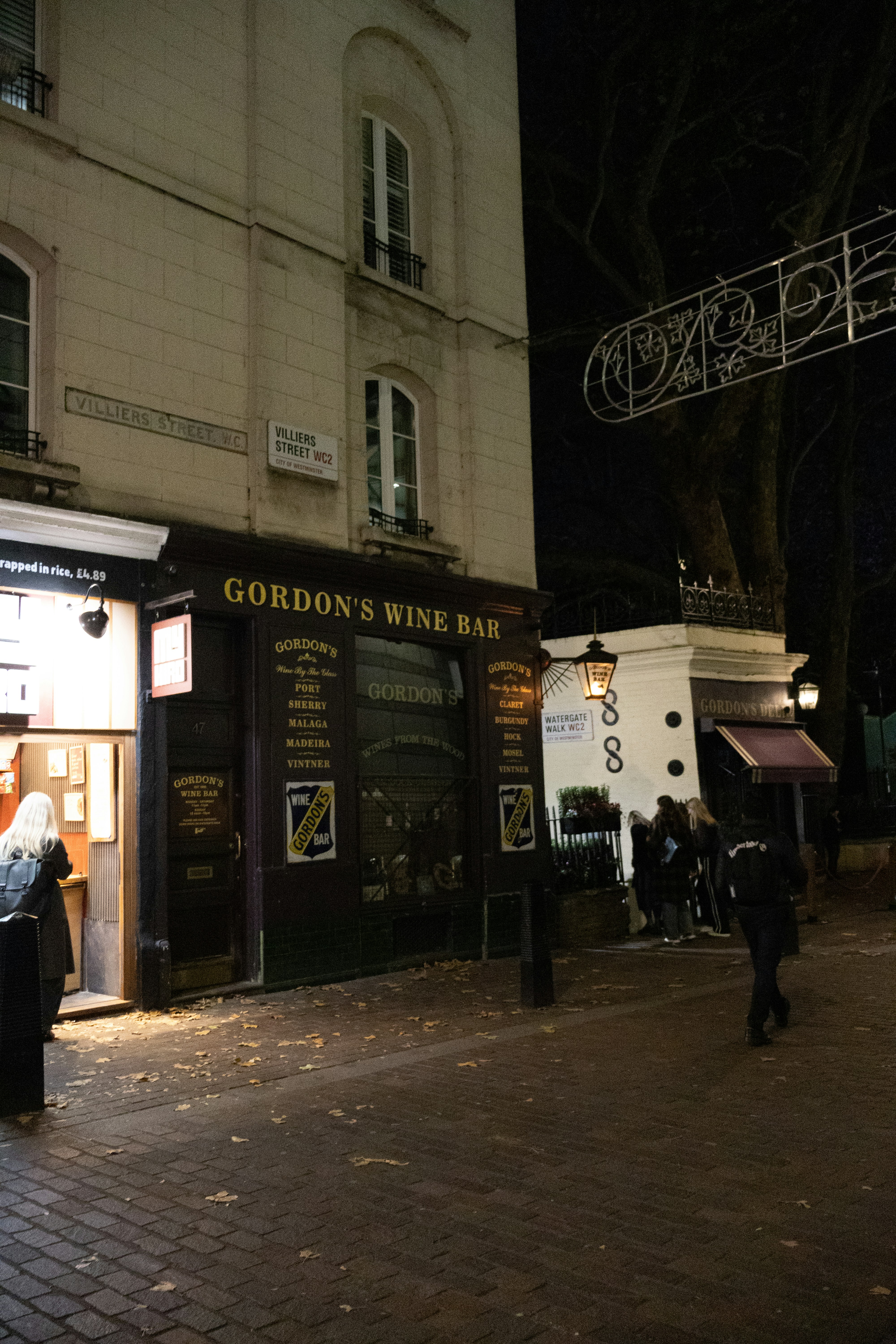 Nocturnal Charm at Gordon's Wine Bar: Warm Light on Cobblestones
