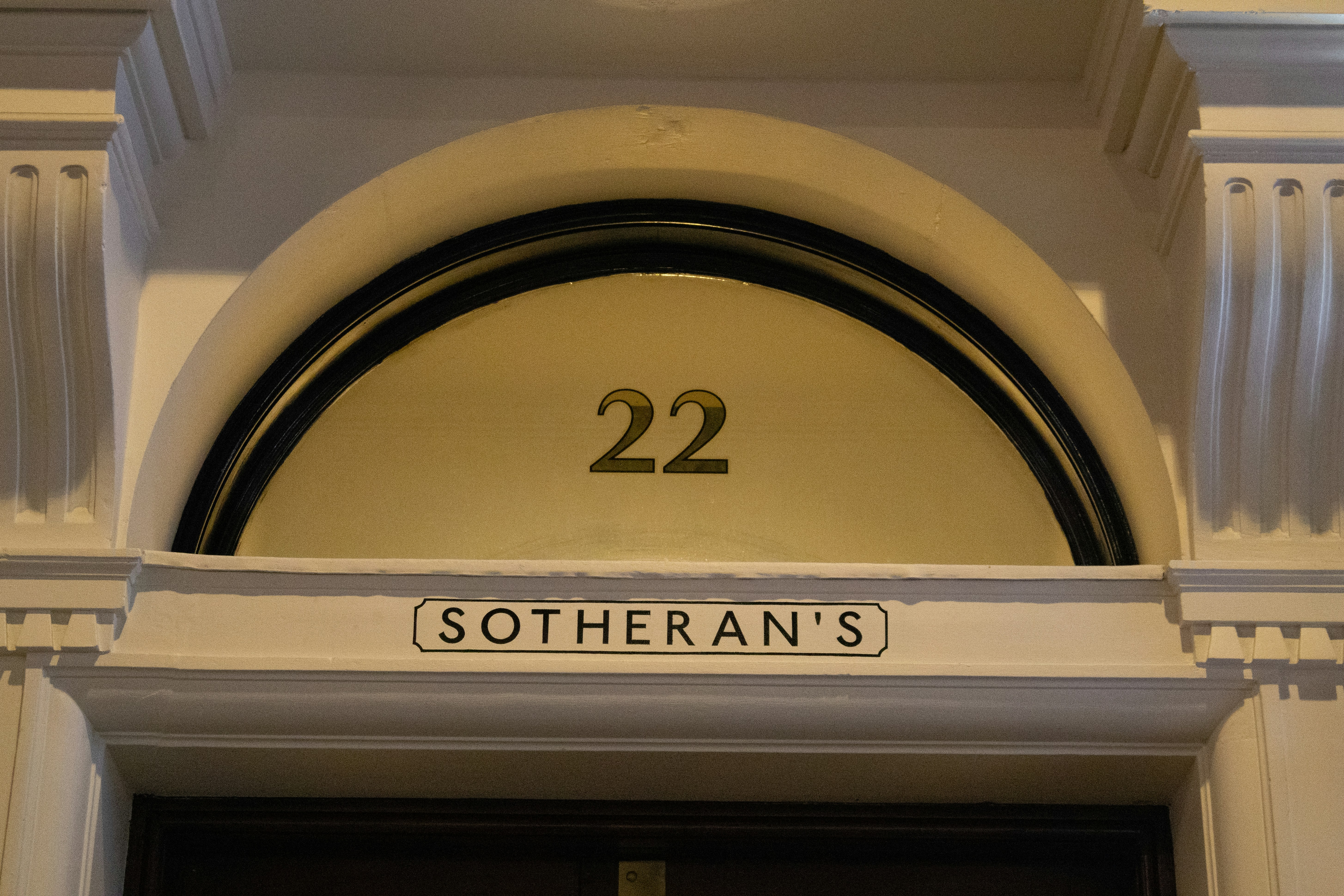 Archway at 22: a cream façade frames a vintage storefront sign