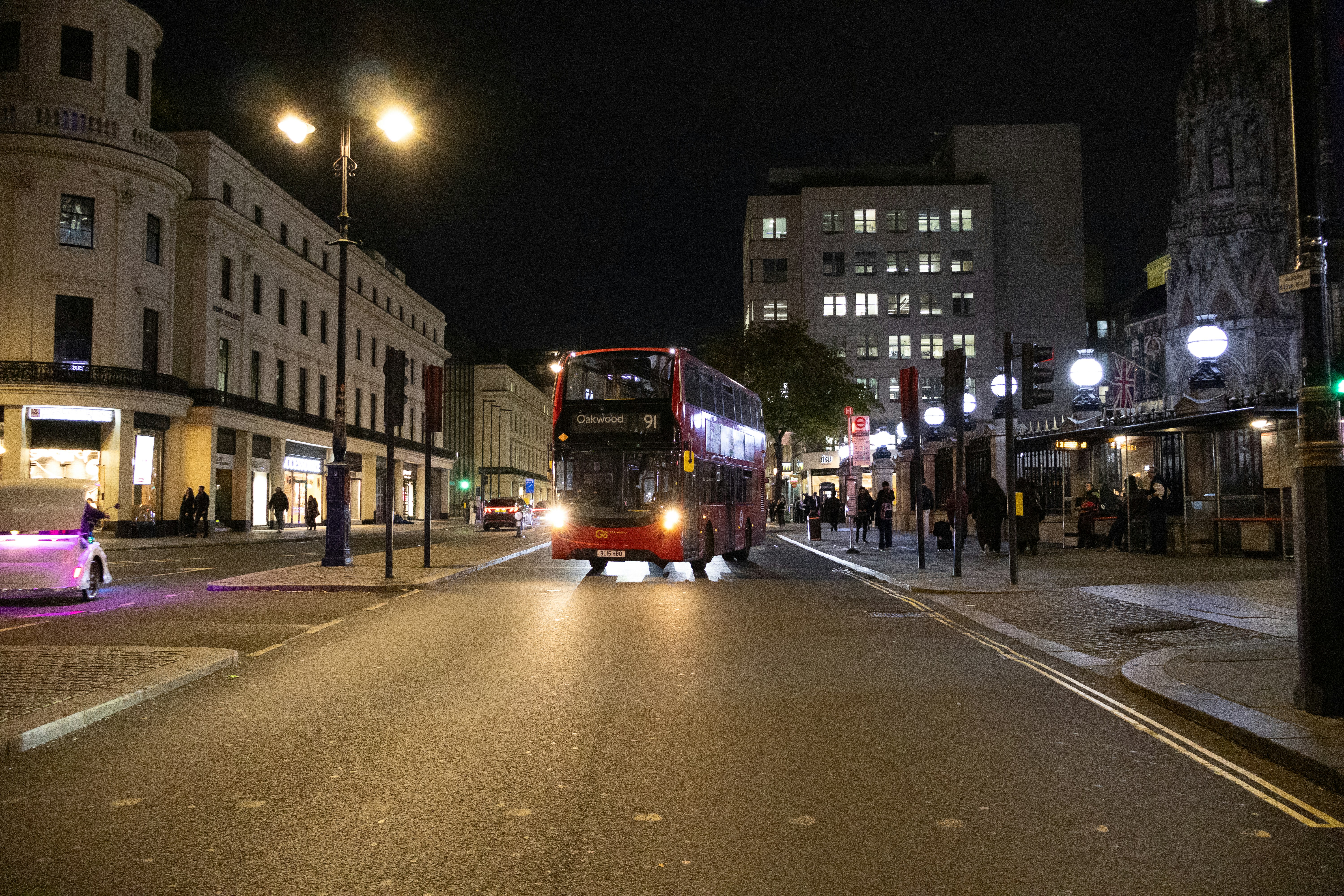 Crimson Double-Decker Crossing a Quiet Night Street