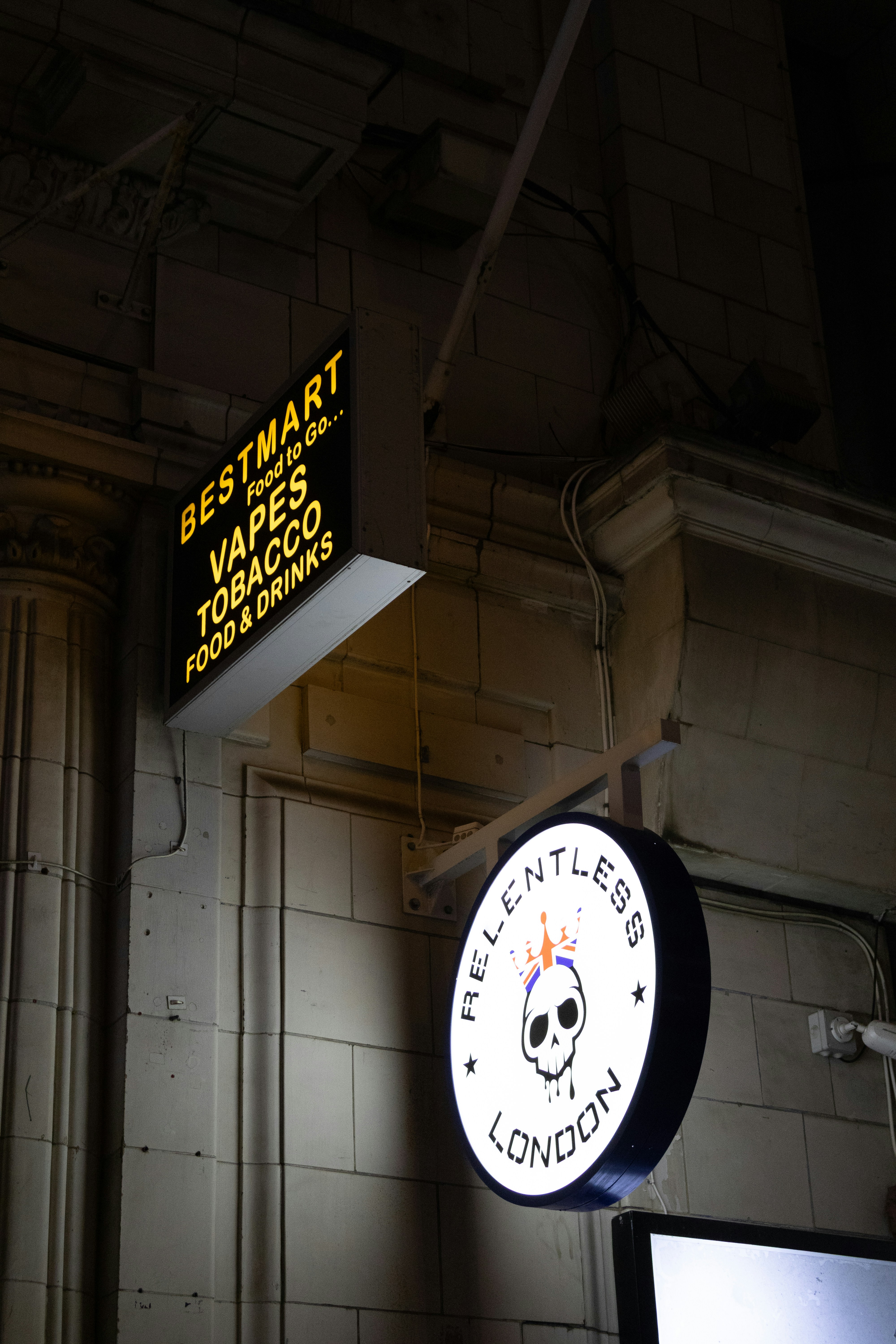Neon Skull Sign Illuminates a Brick Facade at Night