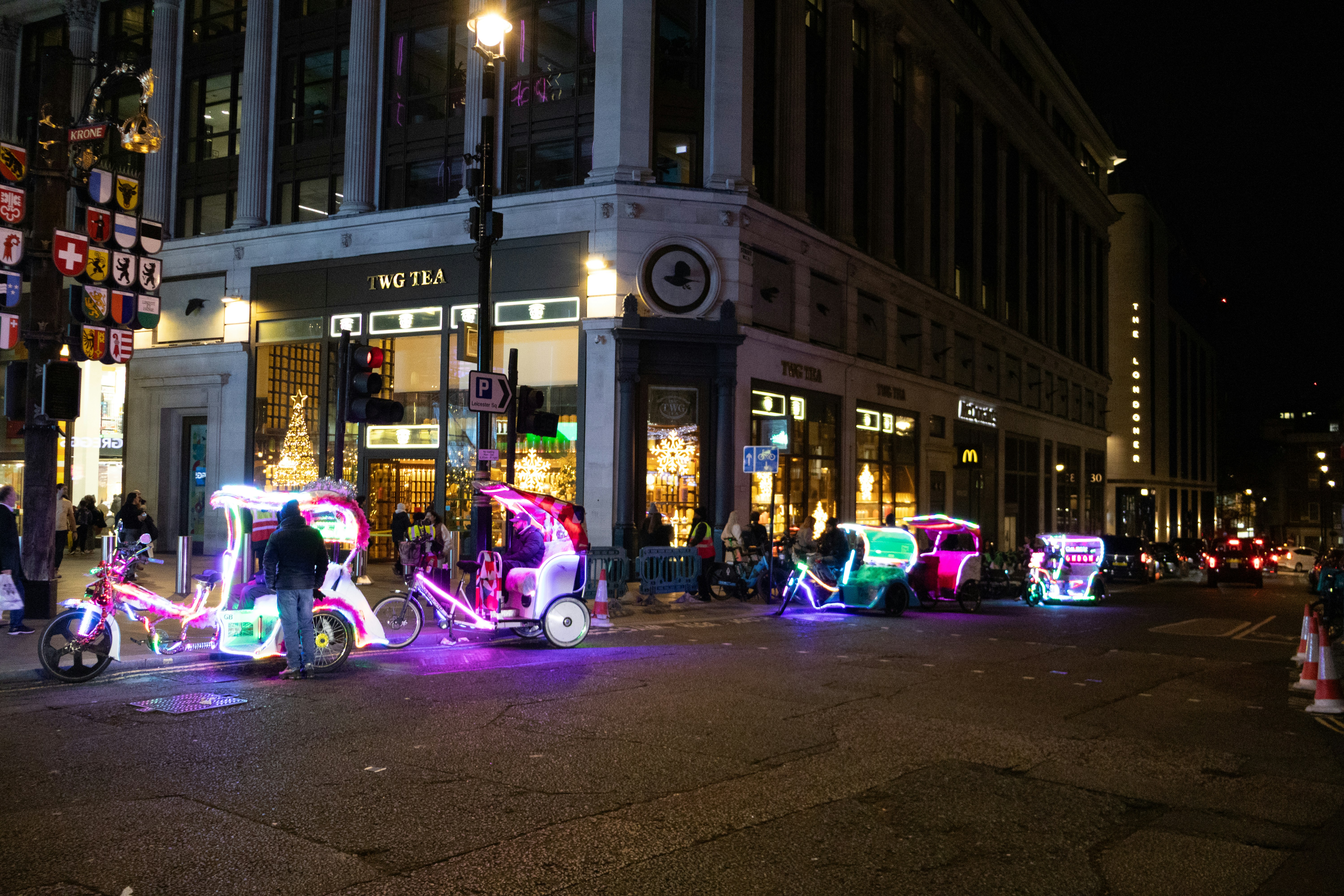 Neon Pedicabs Parade Under City Lights