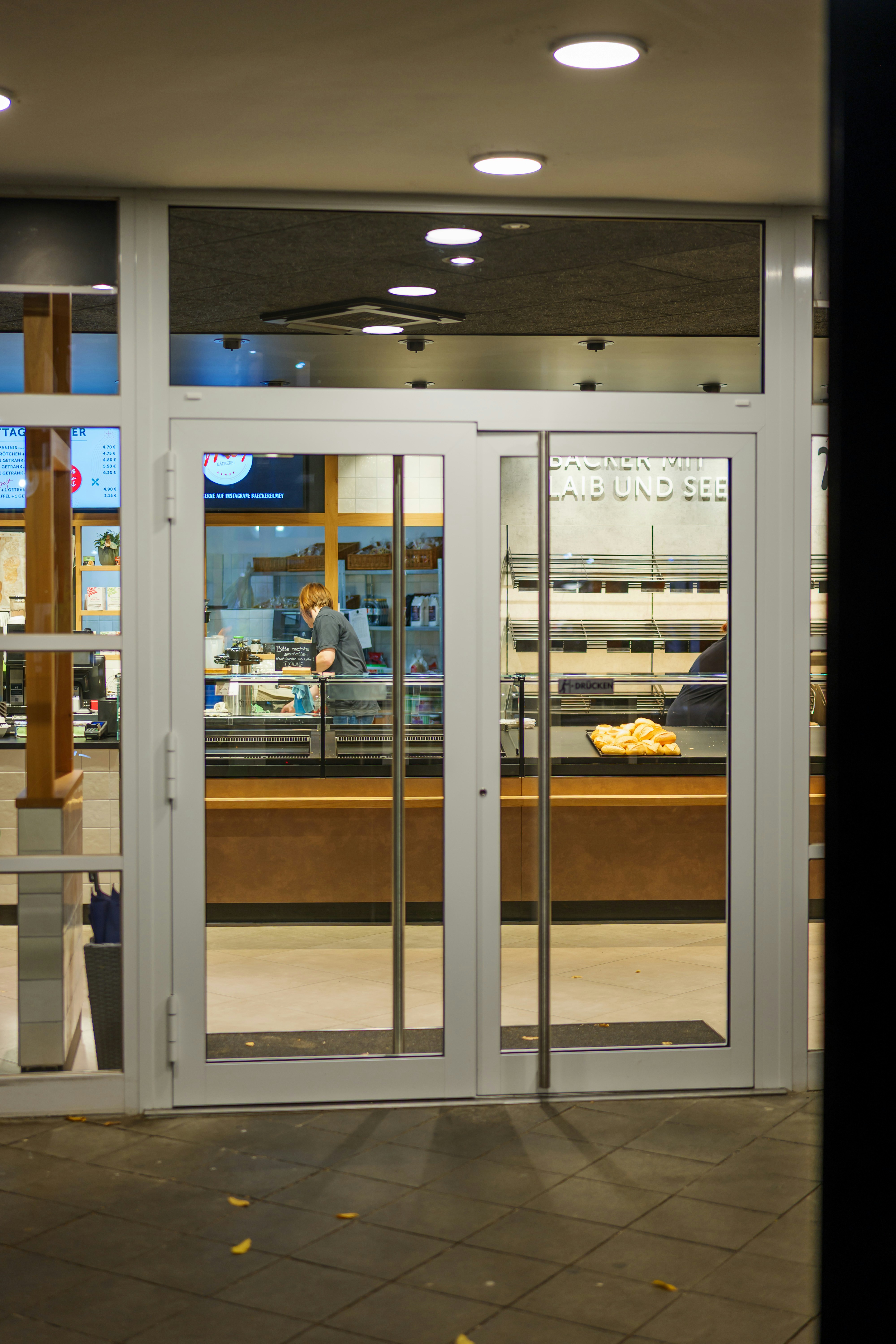 Behind Glass Doors: A Barista at Work in a Quiet Café Kitchen
