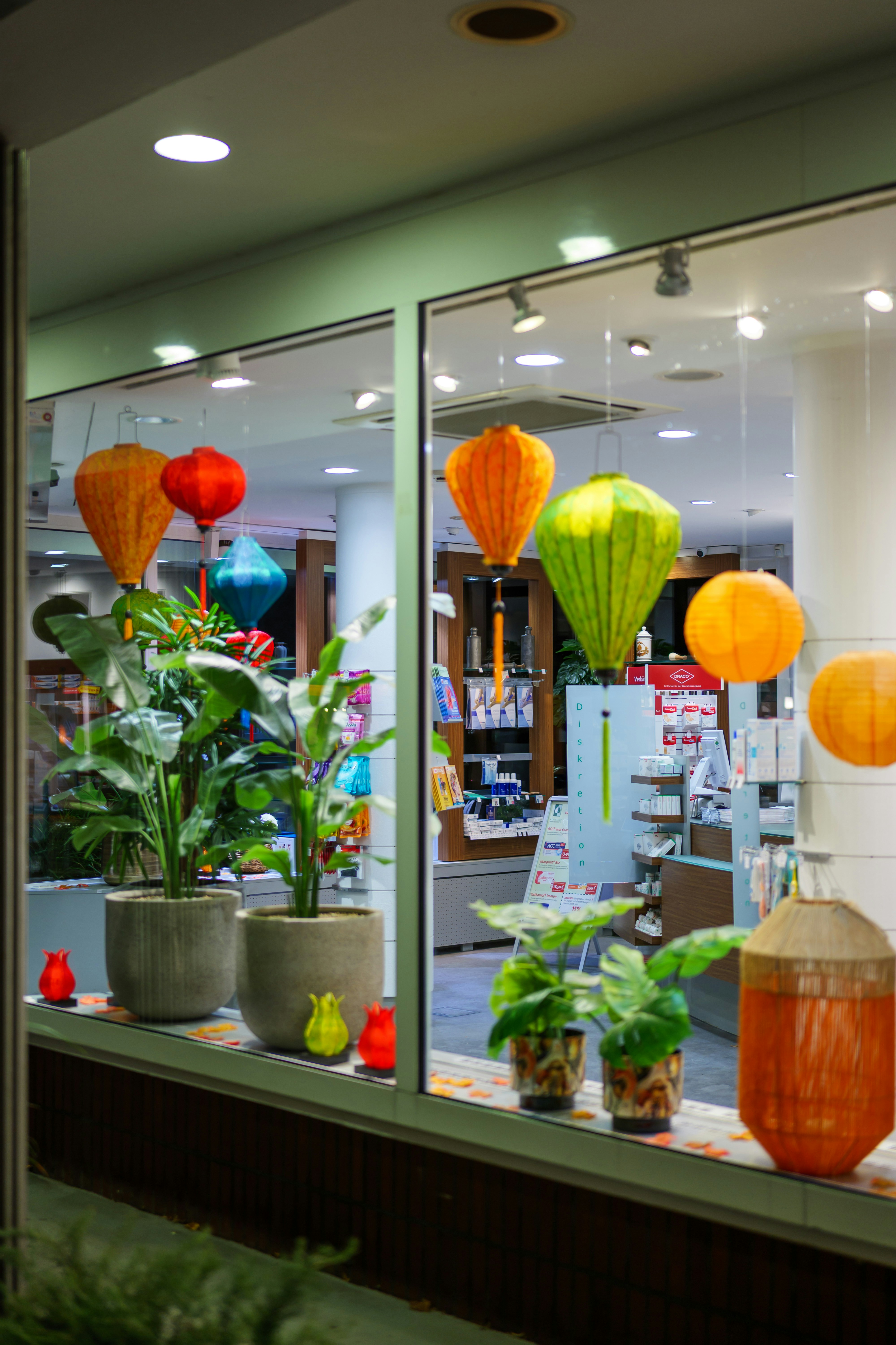 Emerald Lanterns Framing a Lush Storefront Window
