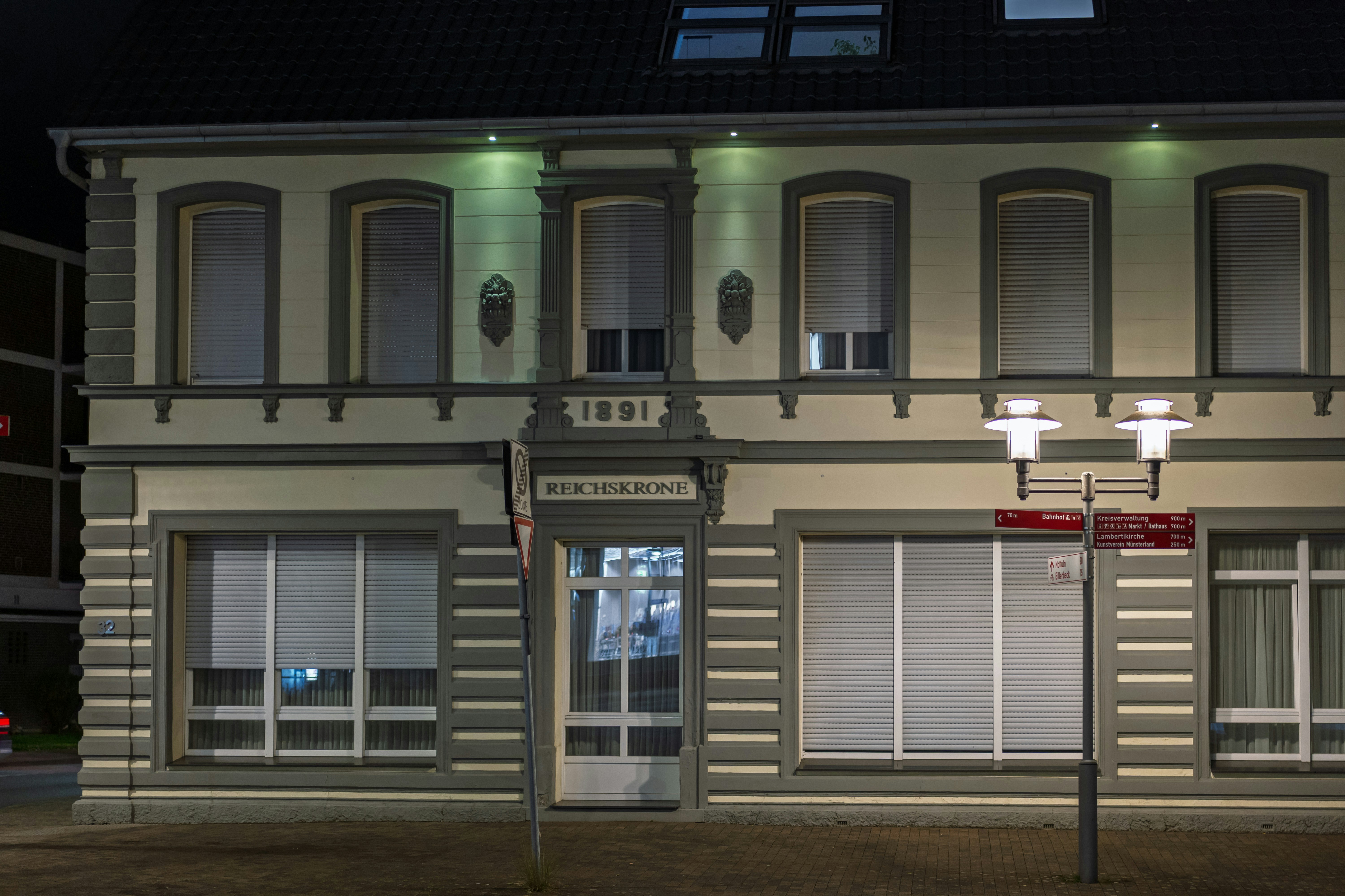Neoclassical Night: Green-Gilded Facade Under Quiet Streetlamps