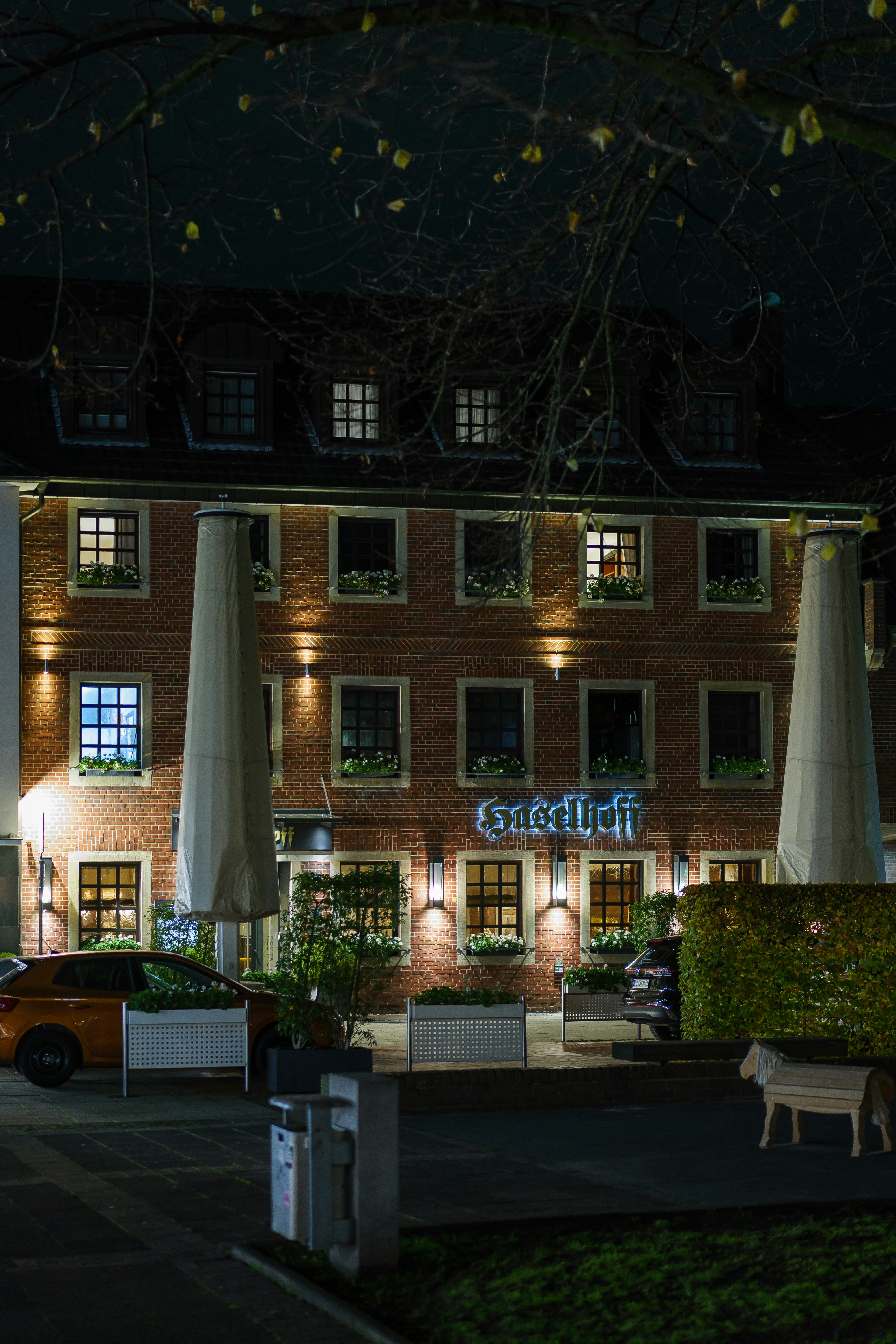 Gasthof by Night: Warm Facade, Blue Sign, Quiet Terrace