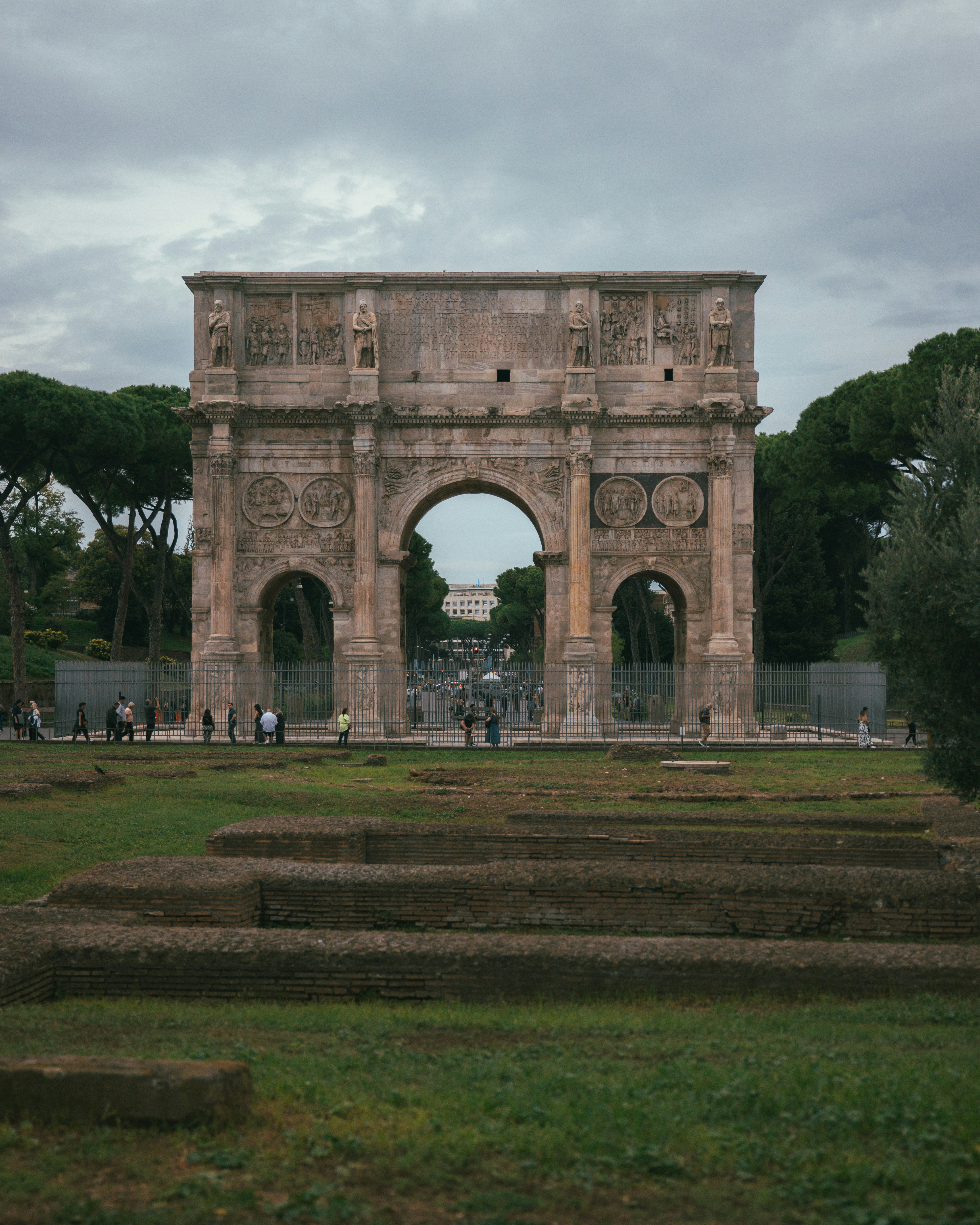 Through the Arch: Rome's Quiet Gate Framed by Trees and Footsteps