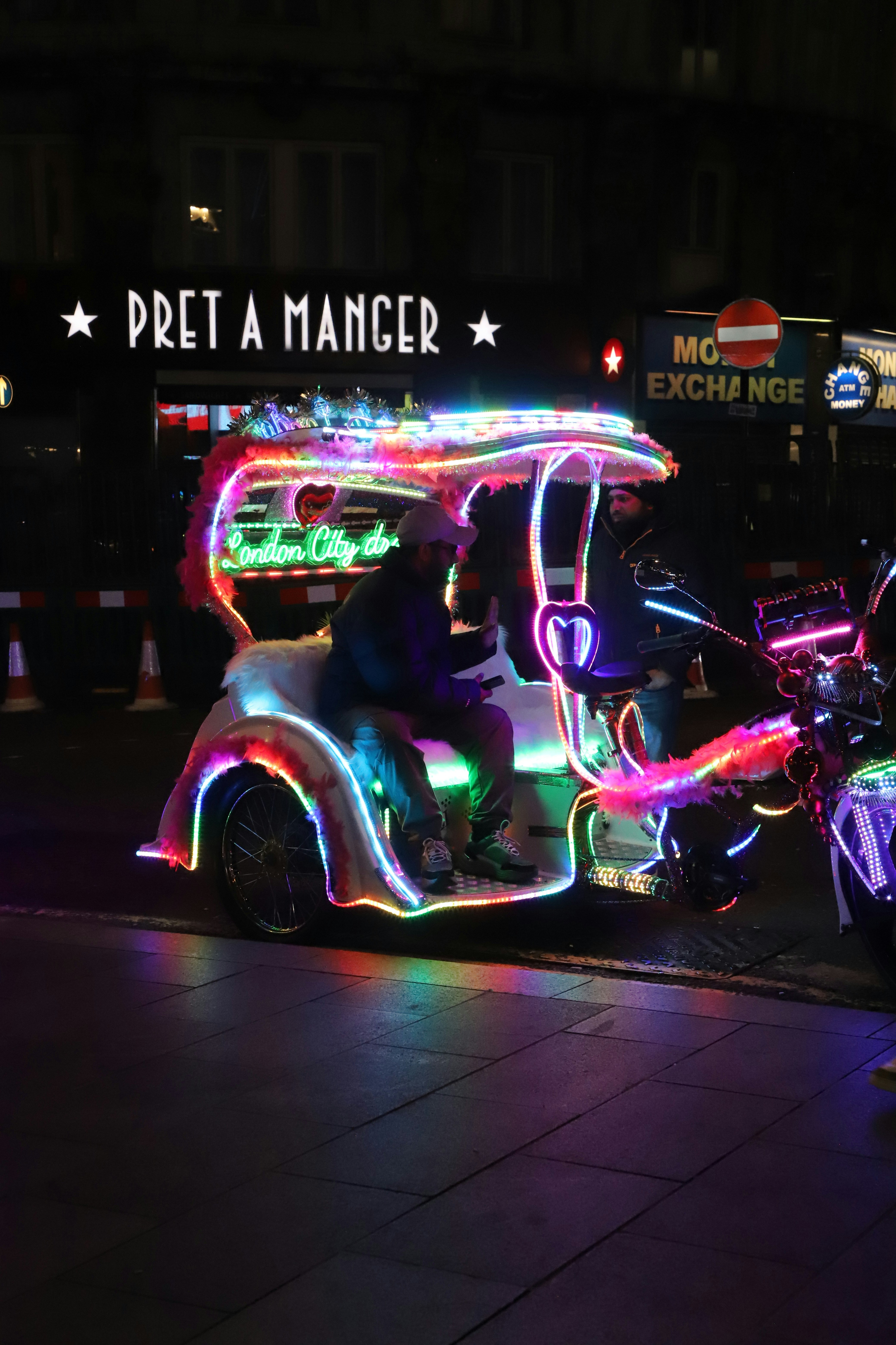 Neon Night Ride: A Pedicab Glowing through a London Street