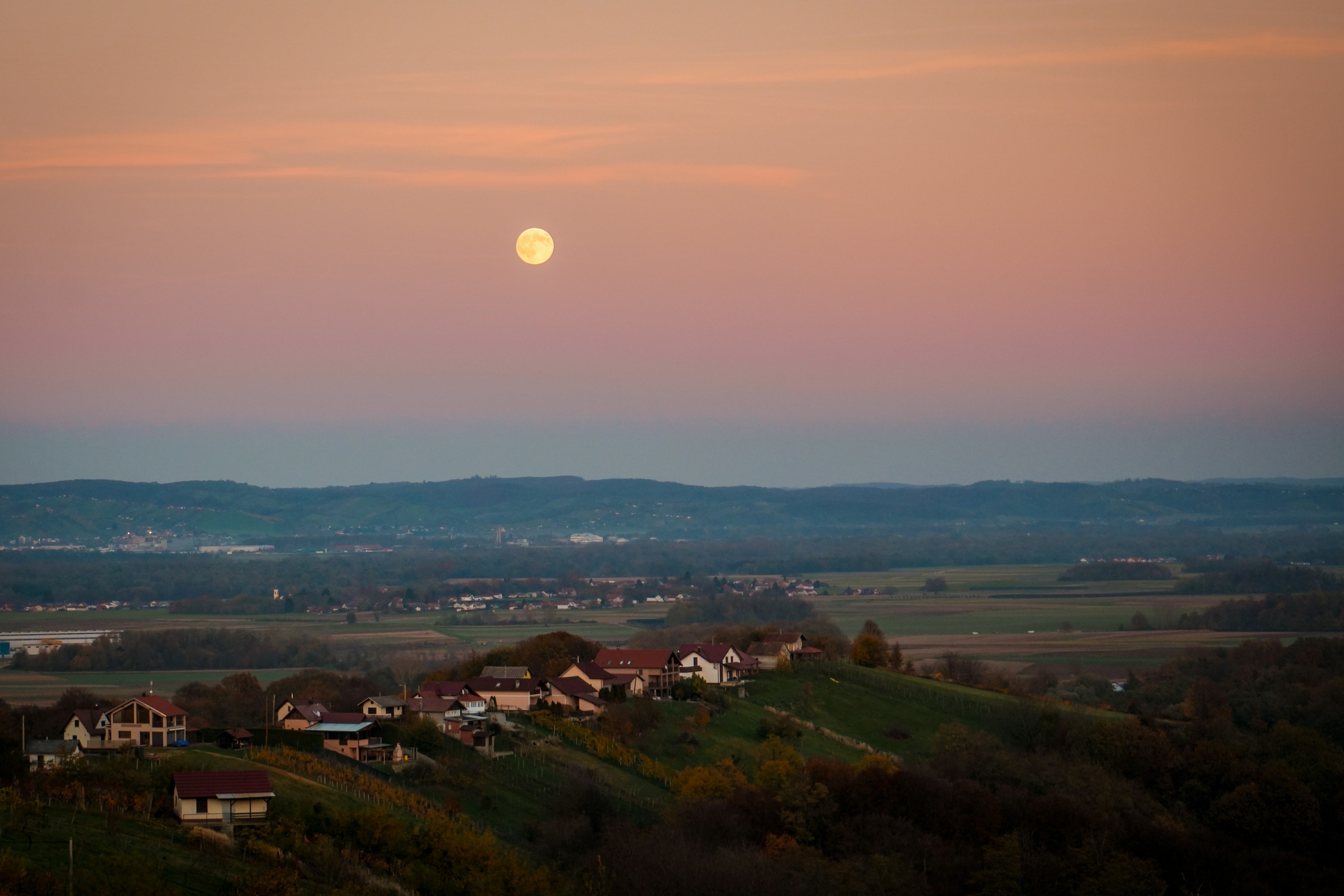 Moonrise Over a Hilltop Village at Dusk, Painted in Pastel Skies