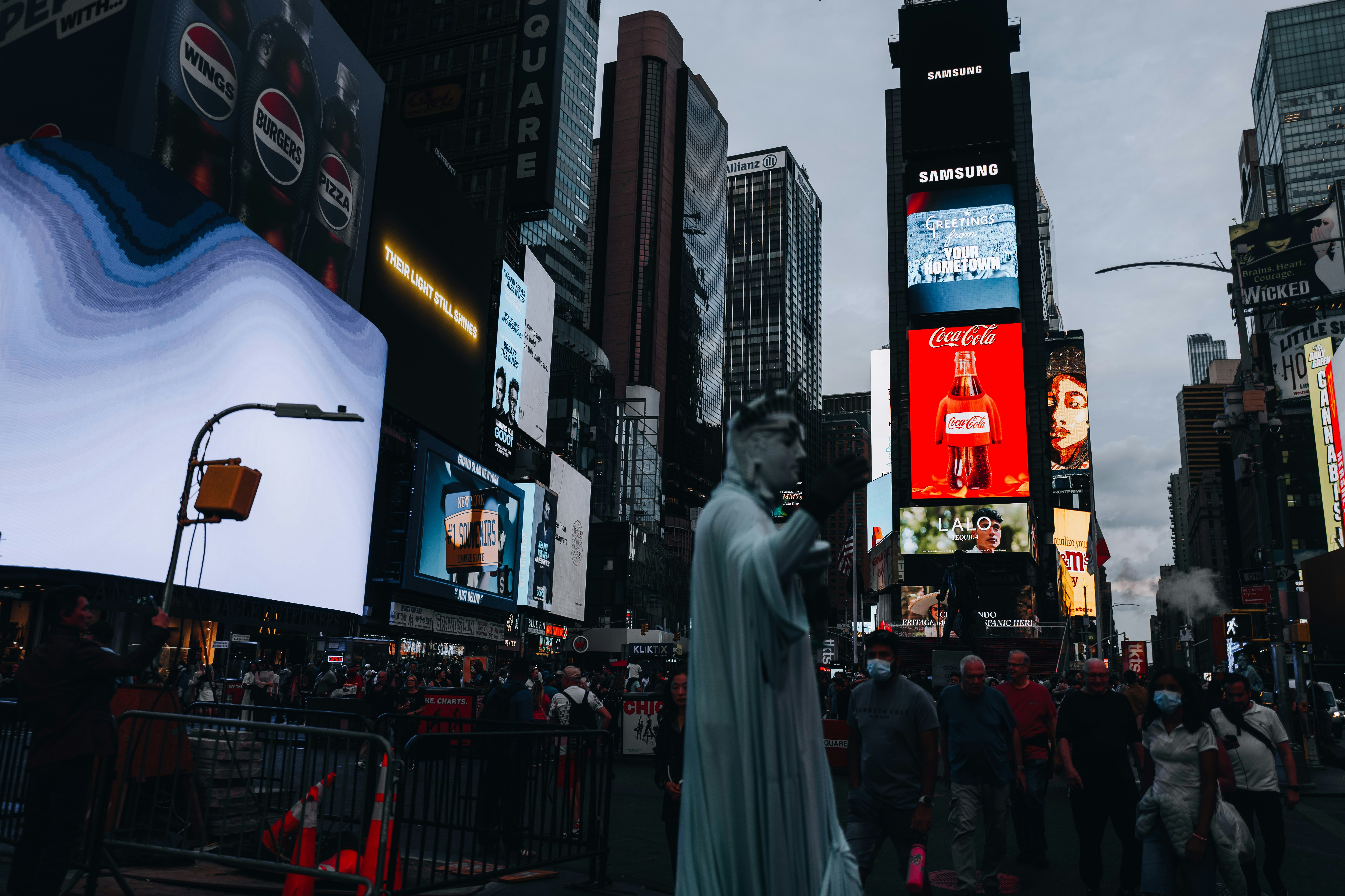 Cloaked Human-Statue Under Giant Neon Screens in Times Square