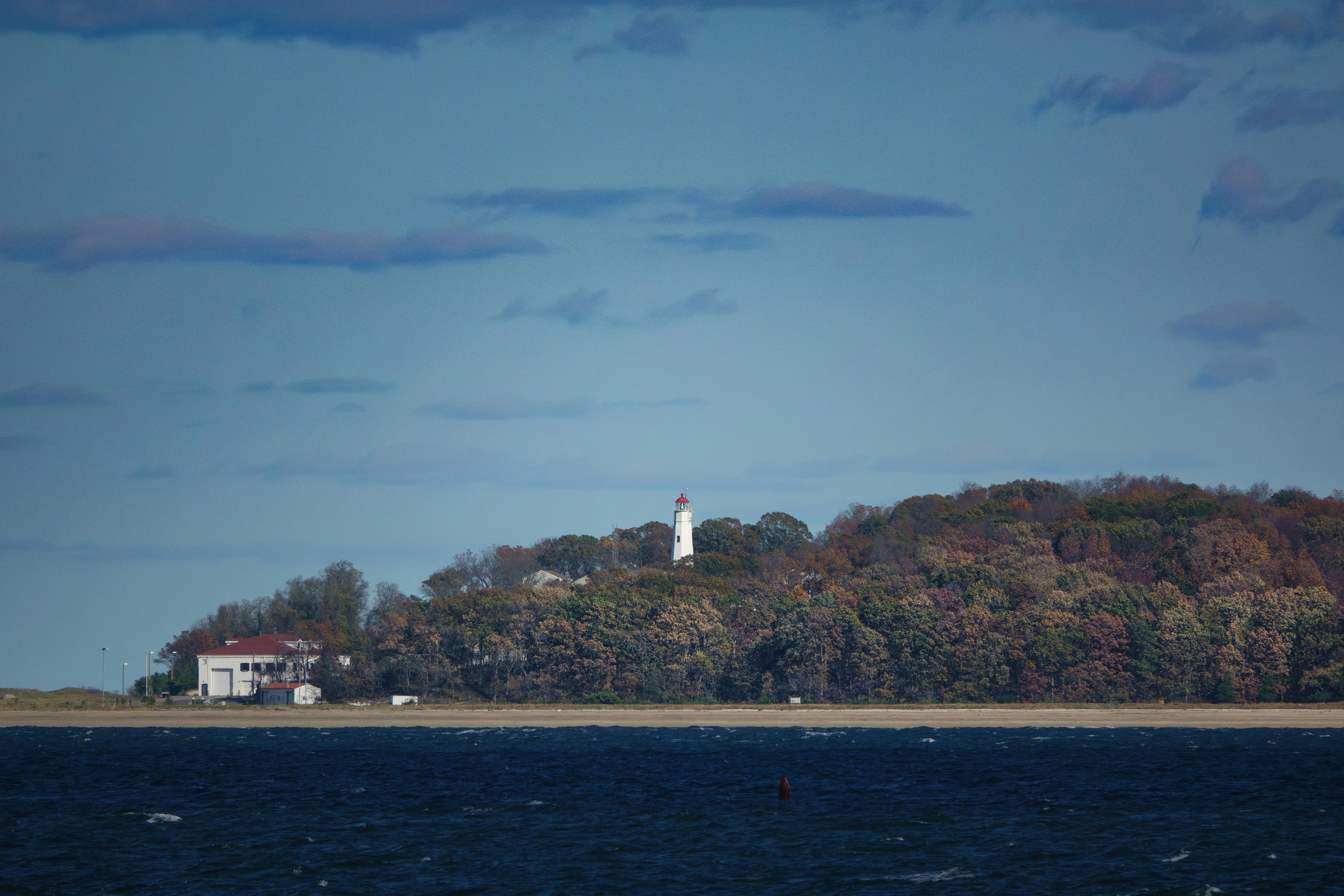 Autumn Ridge Lighthouse: A Quiet Beacon Over Blue Coastal Waters