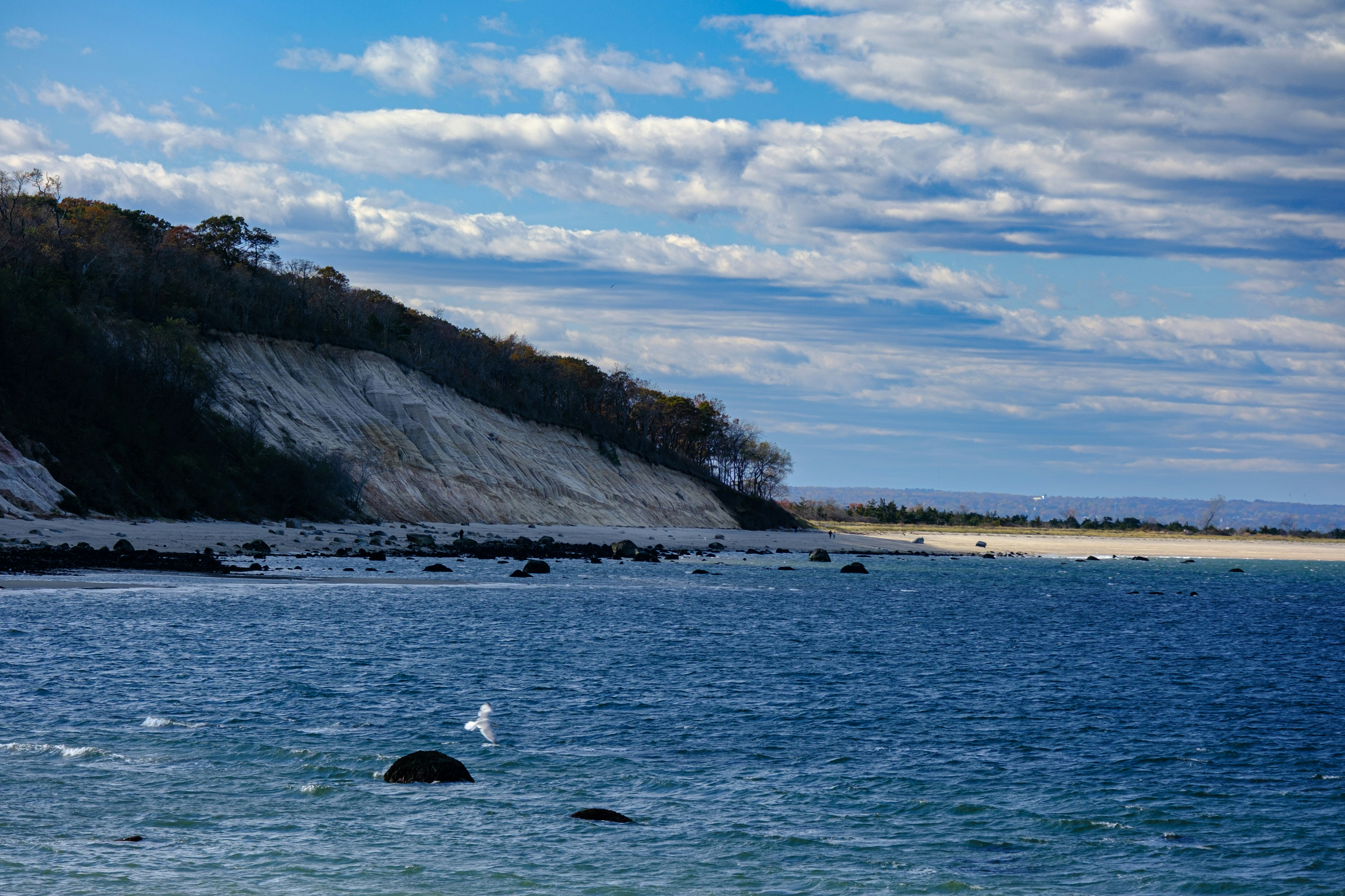Cliffside Ridge Meets Sand and Sea Under a Striped Sky