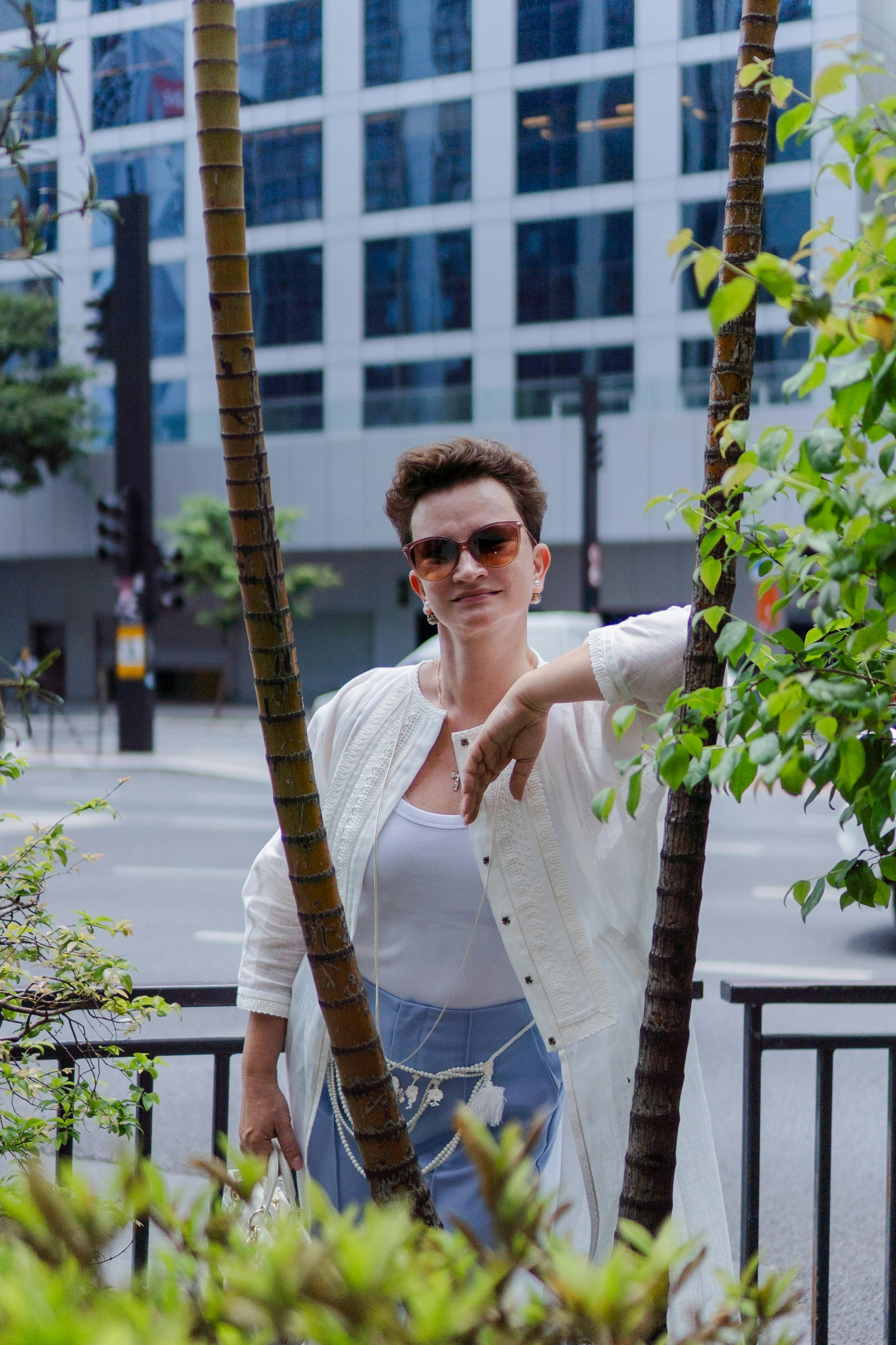 Urban Portrait: Quiet Confidence Framed by Trees and Glass Towers