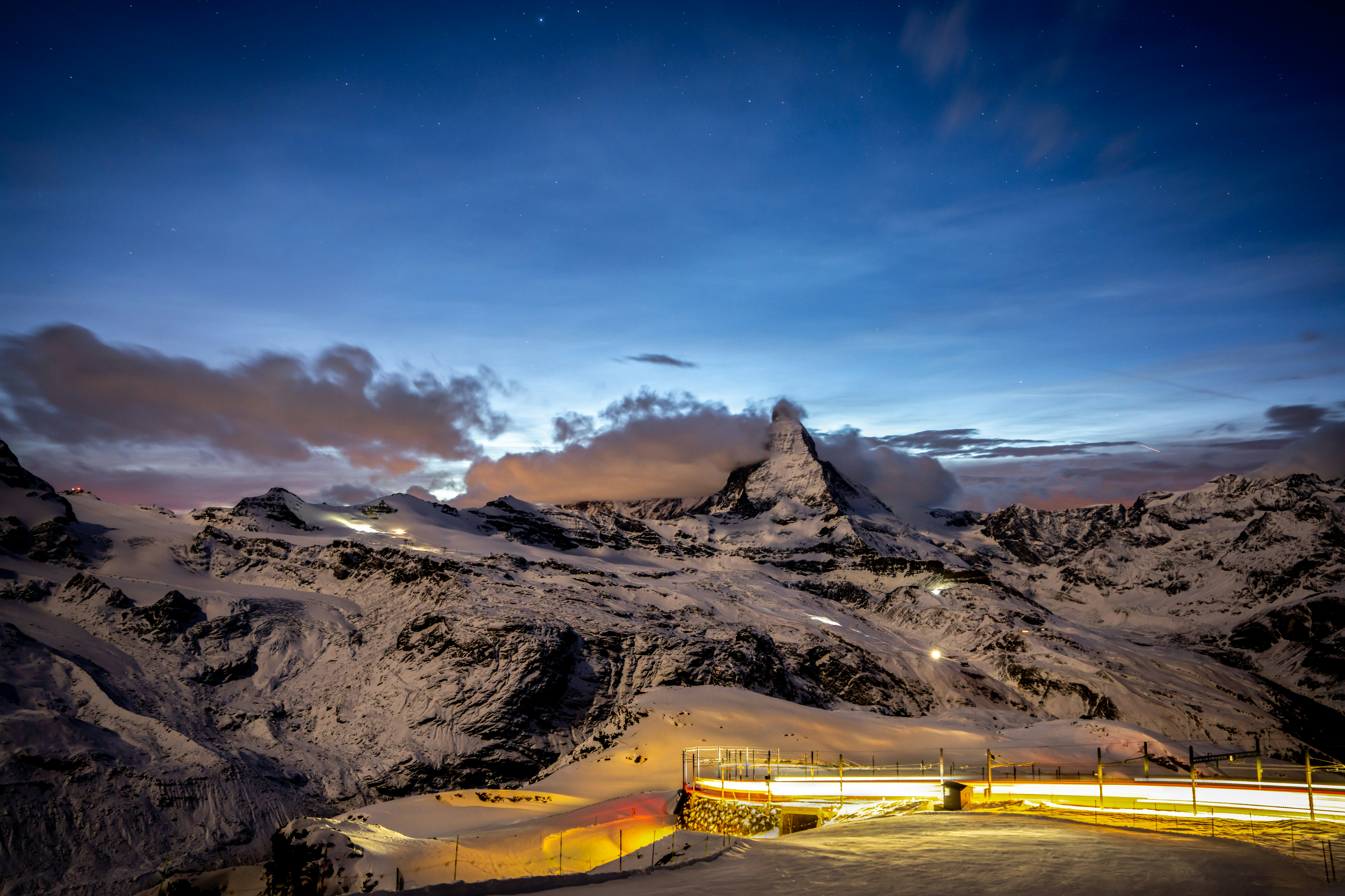 Blue Hour Summit: Starry Sky Over a Snowbound Alpine Crest