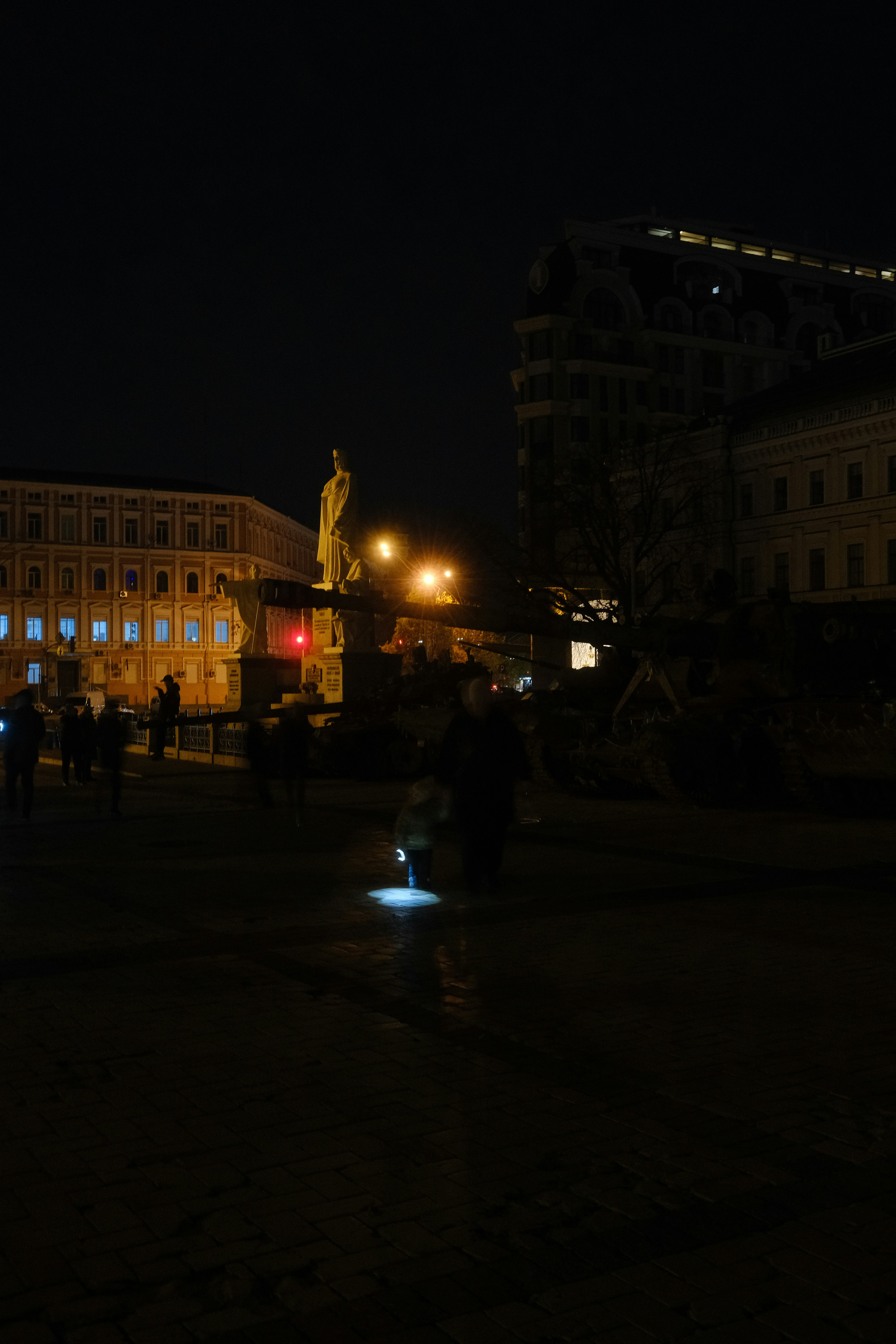 Amber Spotlight: Nighttime Statue Over a Quiet City Square