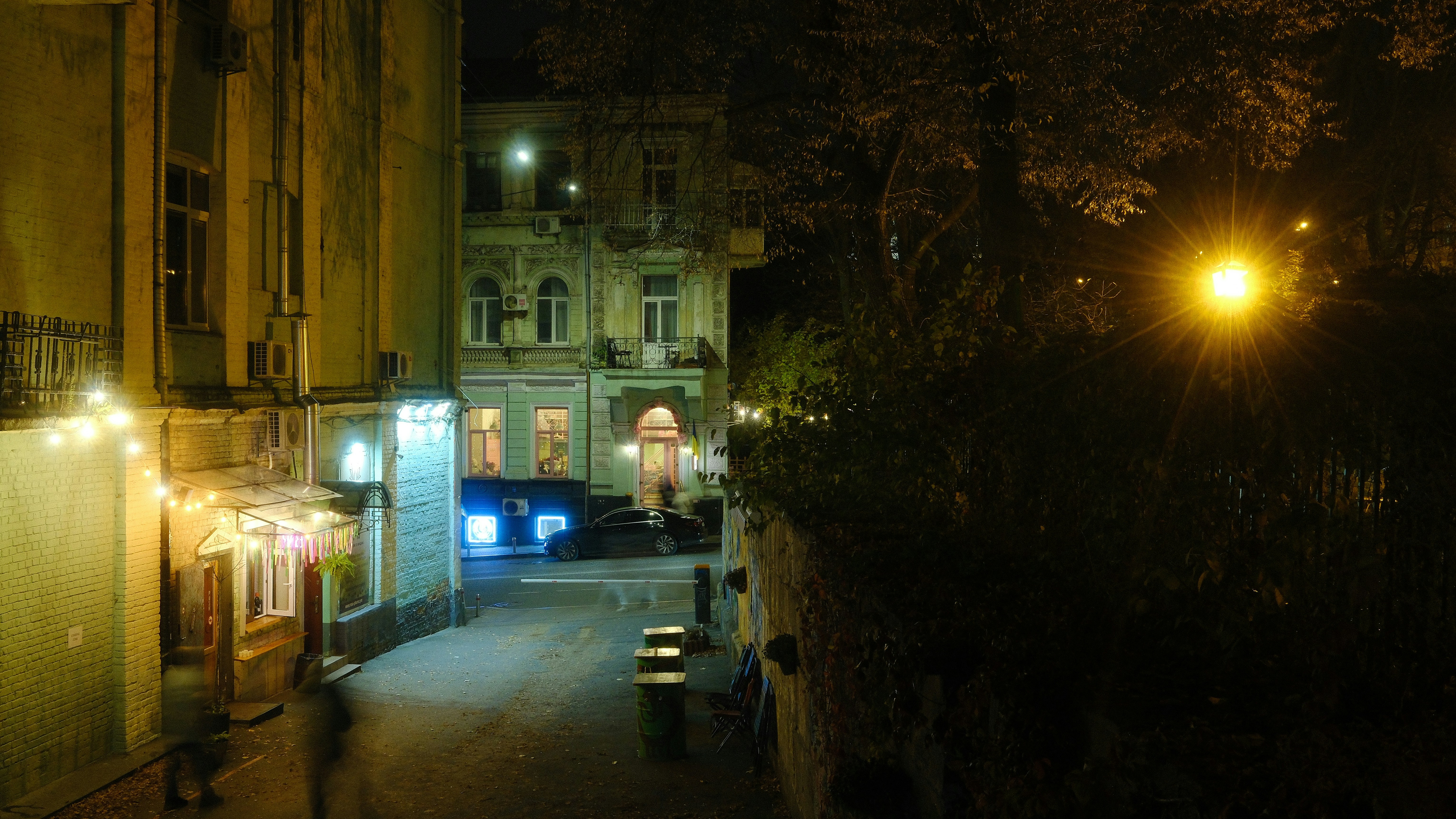 Blue doorway beacon in an amber-lit urban night alley