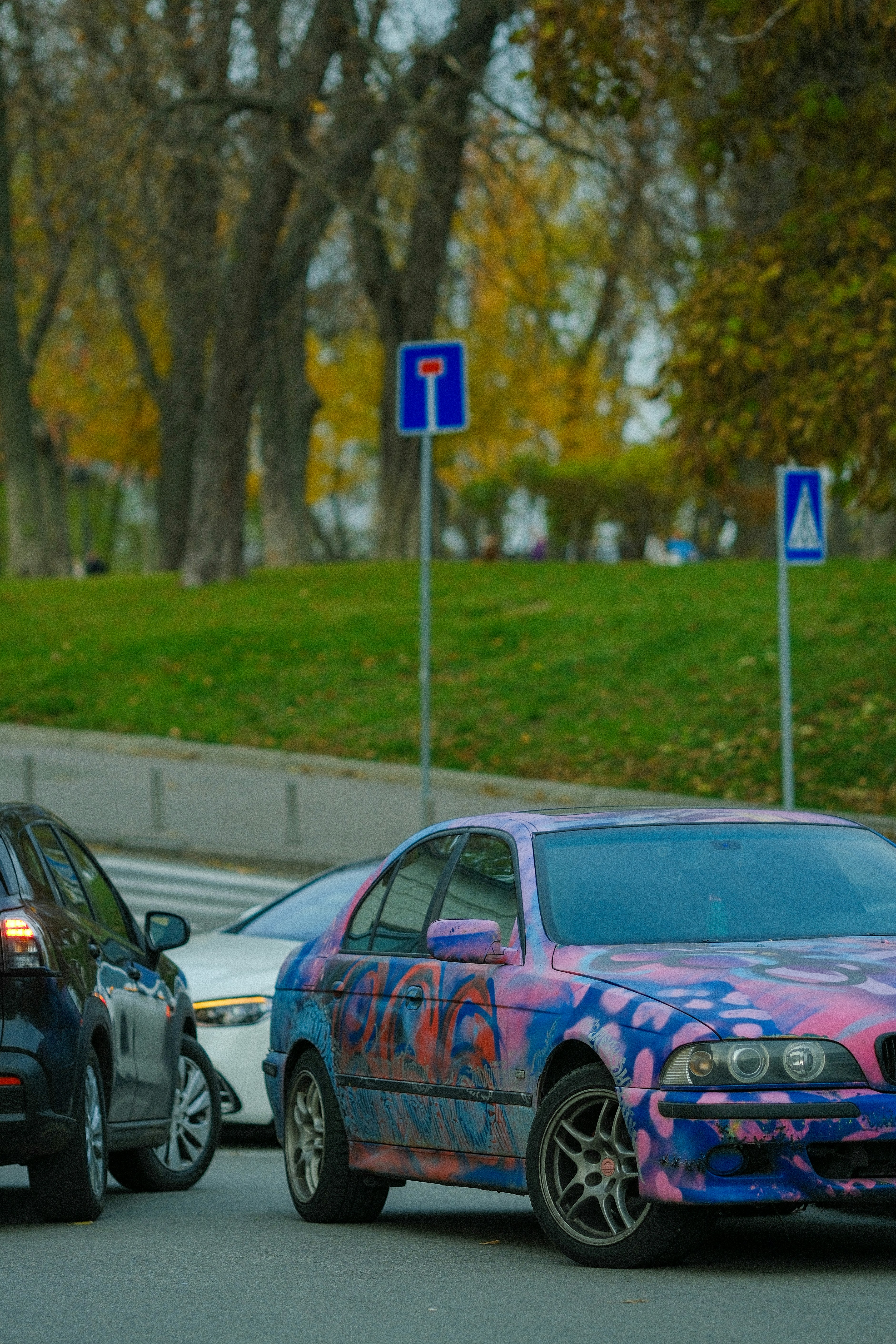 Graffiti-Glossed Sedan at the Edge of Autumn Traffic