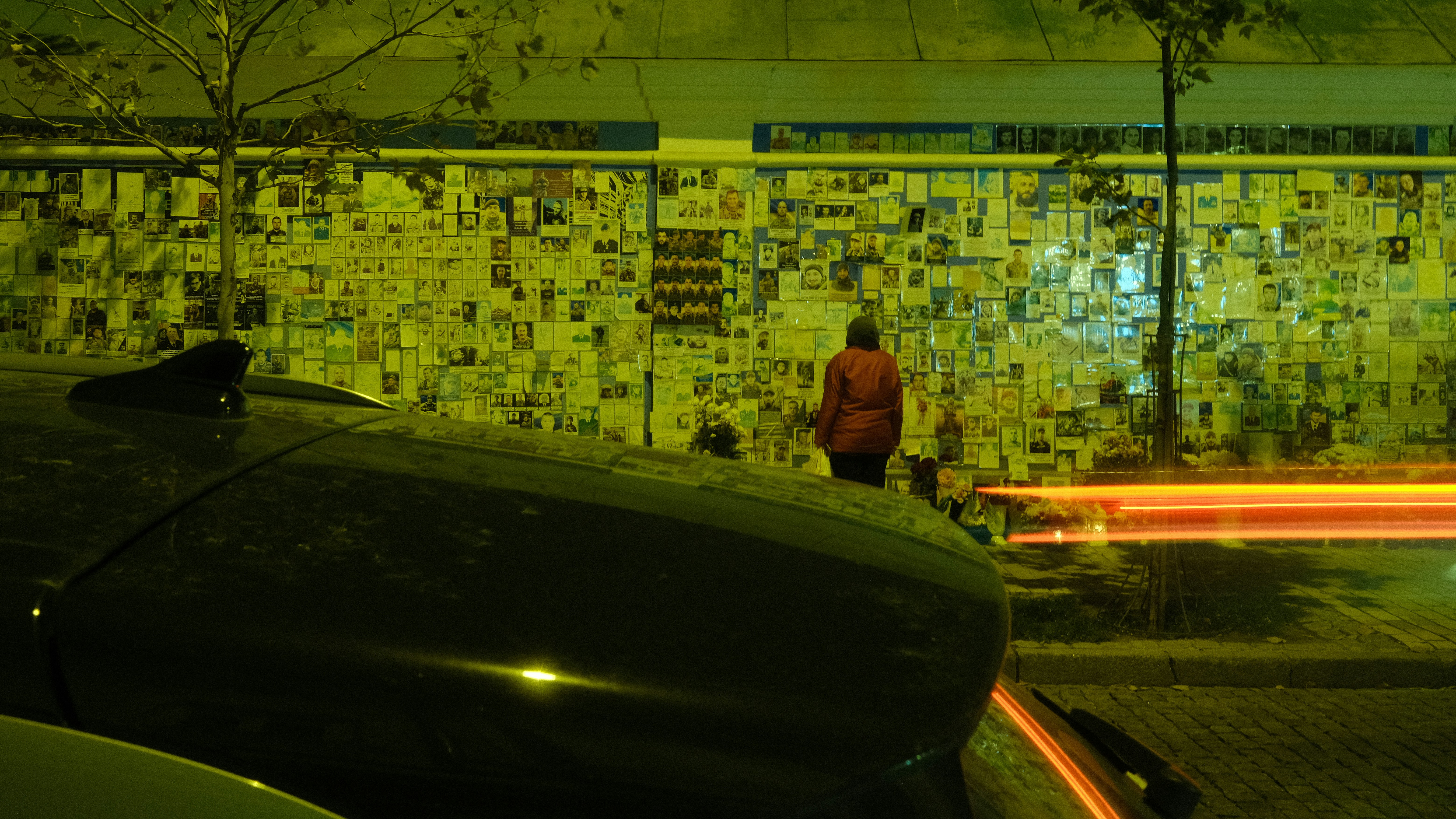 Midnight Mosaic: A Red-Jacket Figure Before a Wall of Flyers
