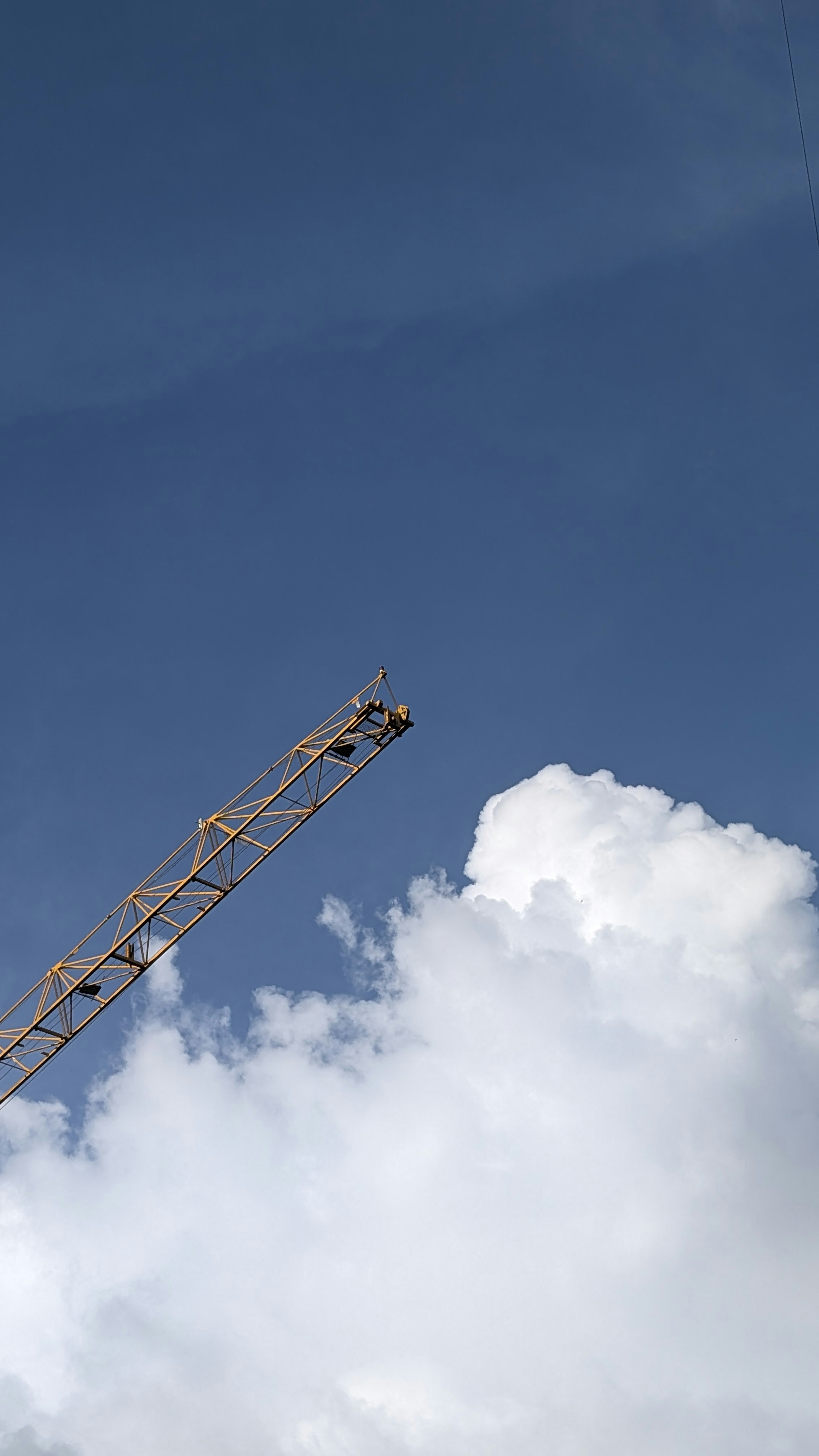 Construction crane infront of clouds in a blue sky