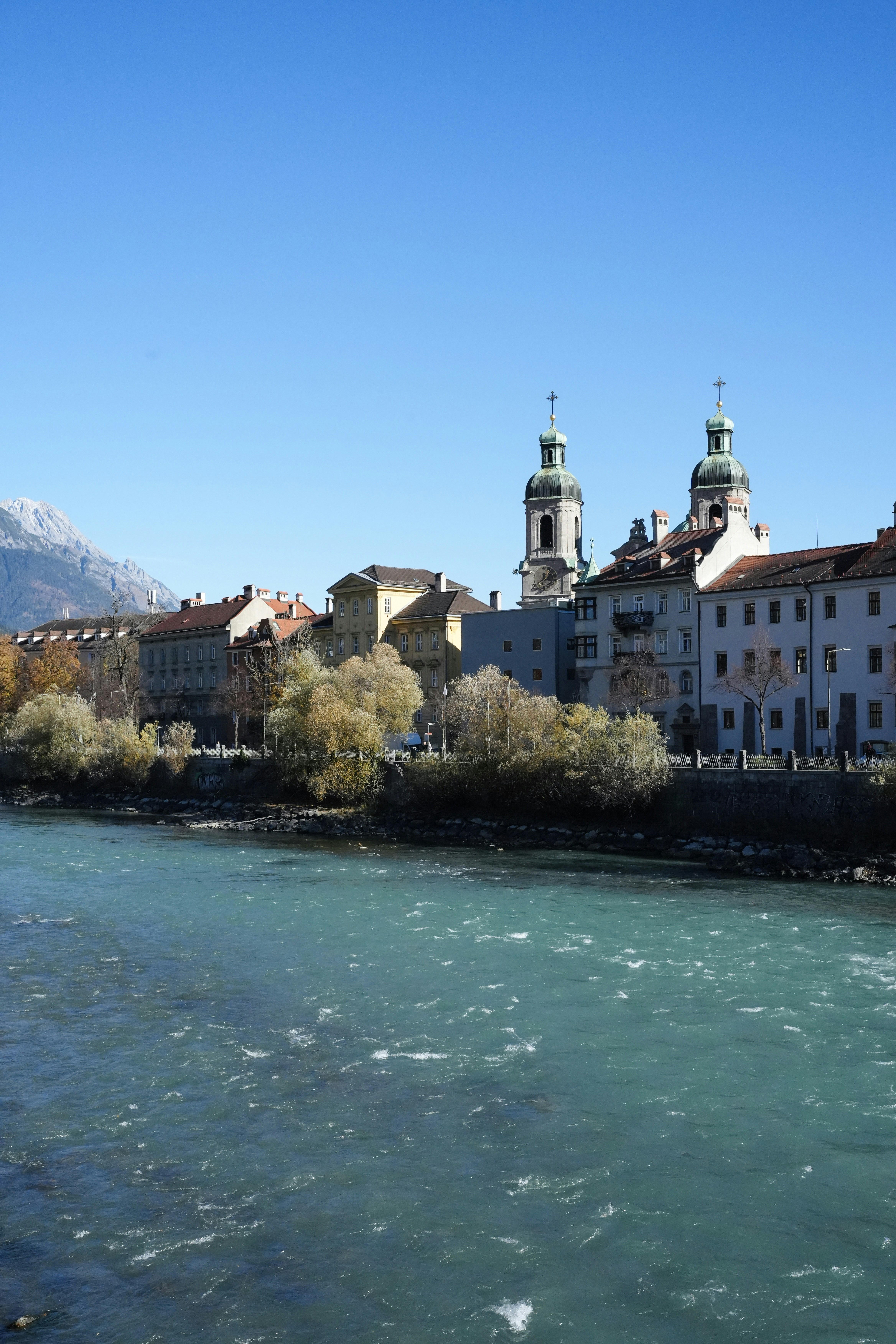 Domed Towers and Turquoise River: A Sunlit Riverside Town